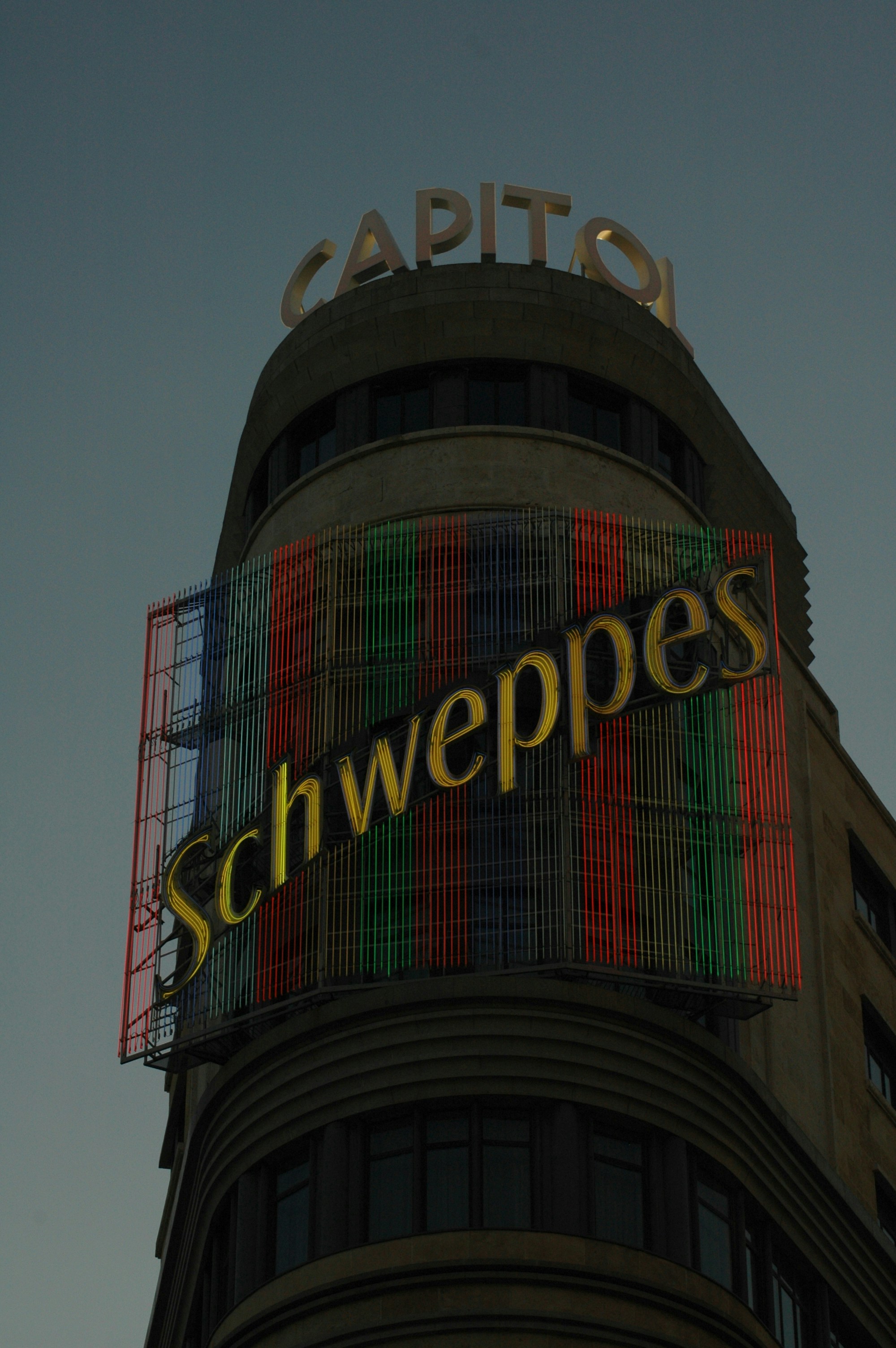 Neon Signover: Schweppes on a Clocktower Facade