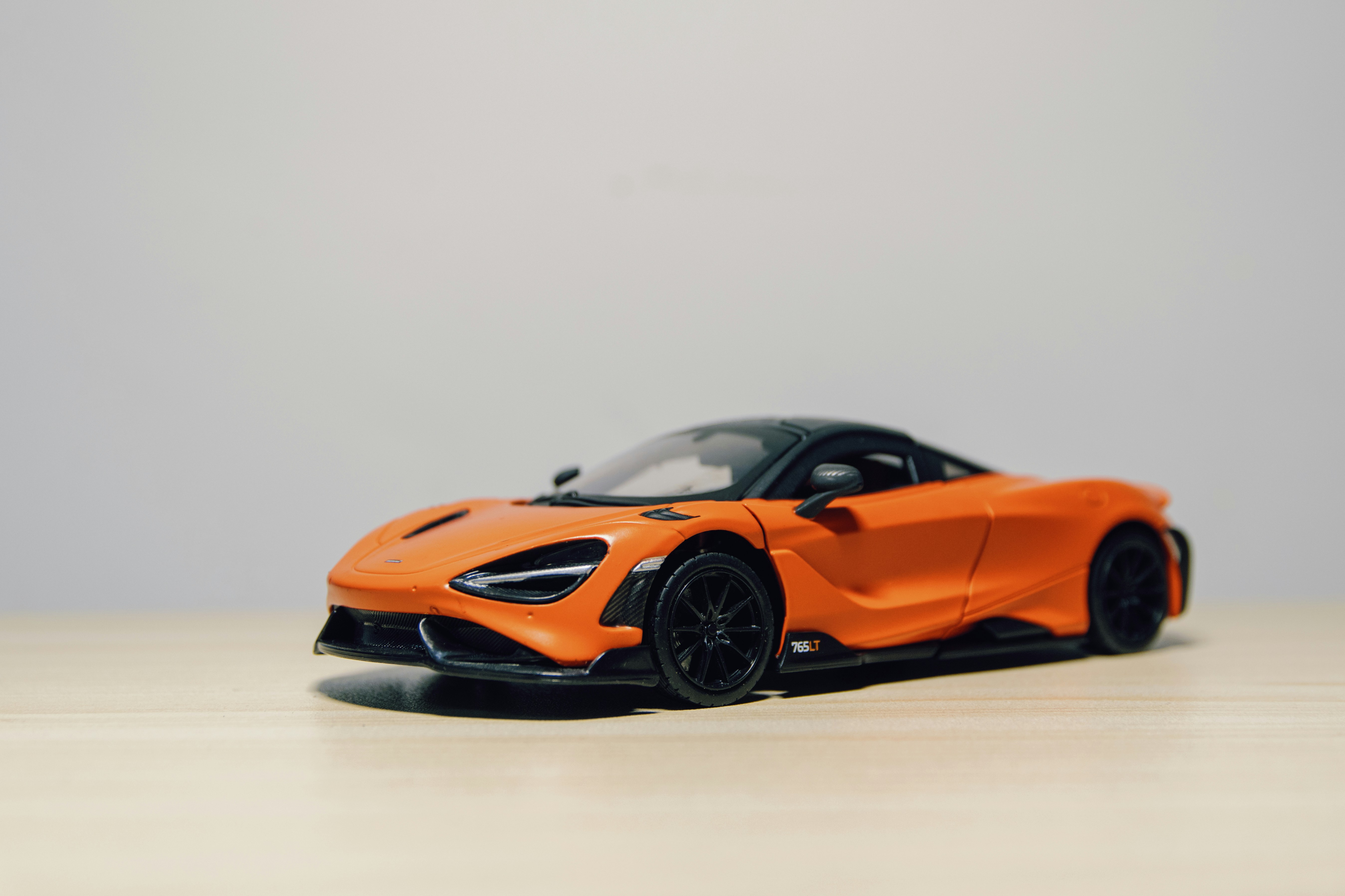 An orange sports car sitting on top of a wooden table photo – Free ...