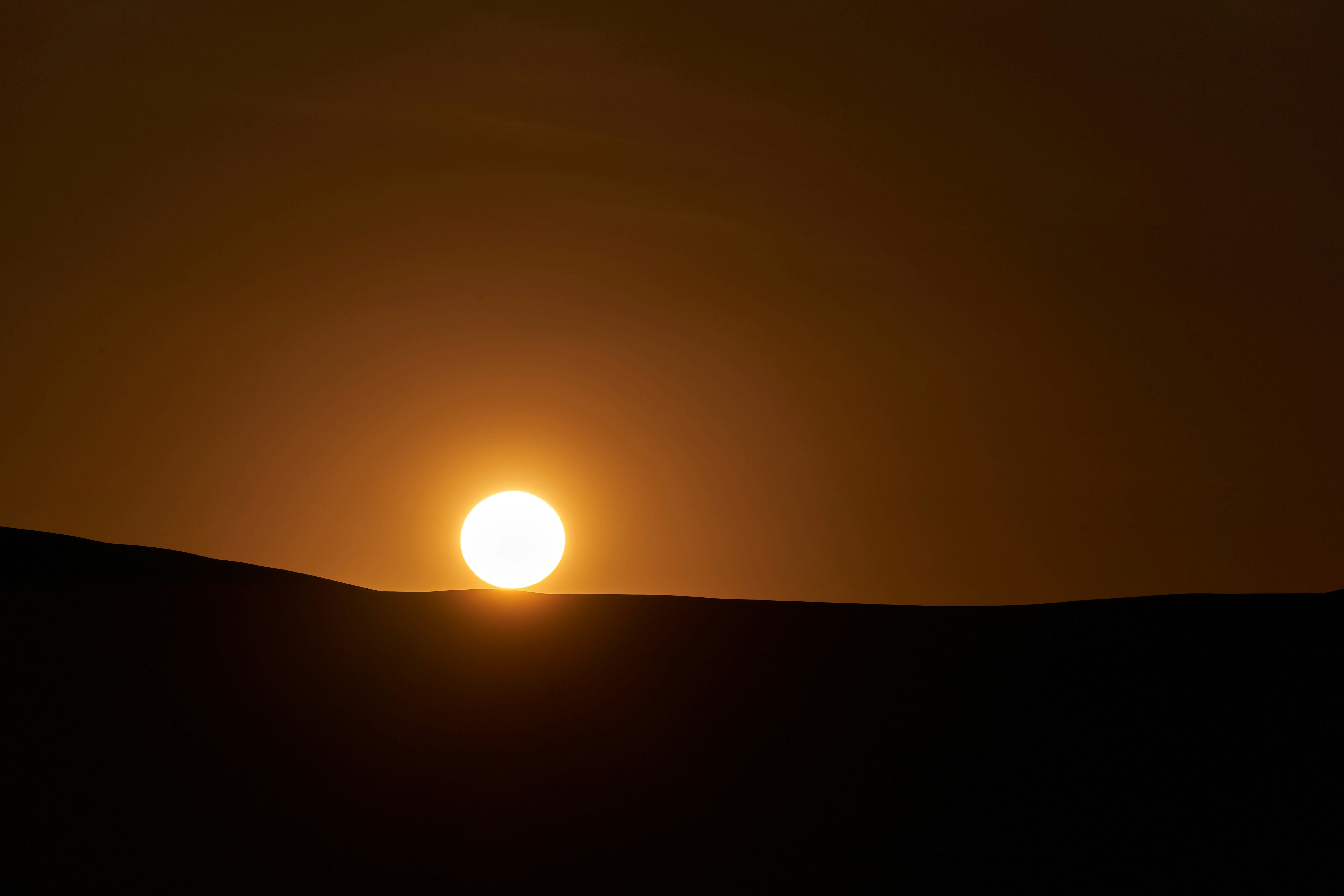 The sun is setting in the sky over a hill photo – Free Wallpapers Image ...