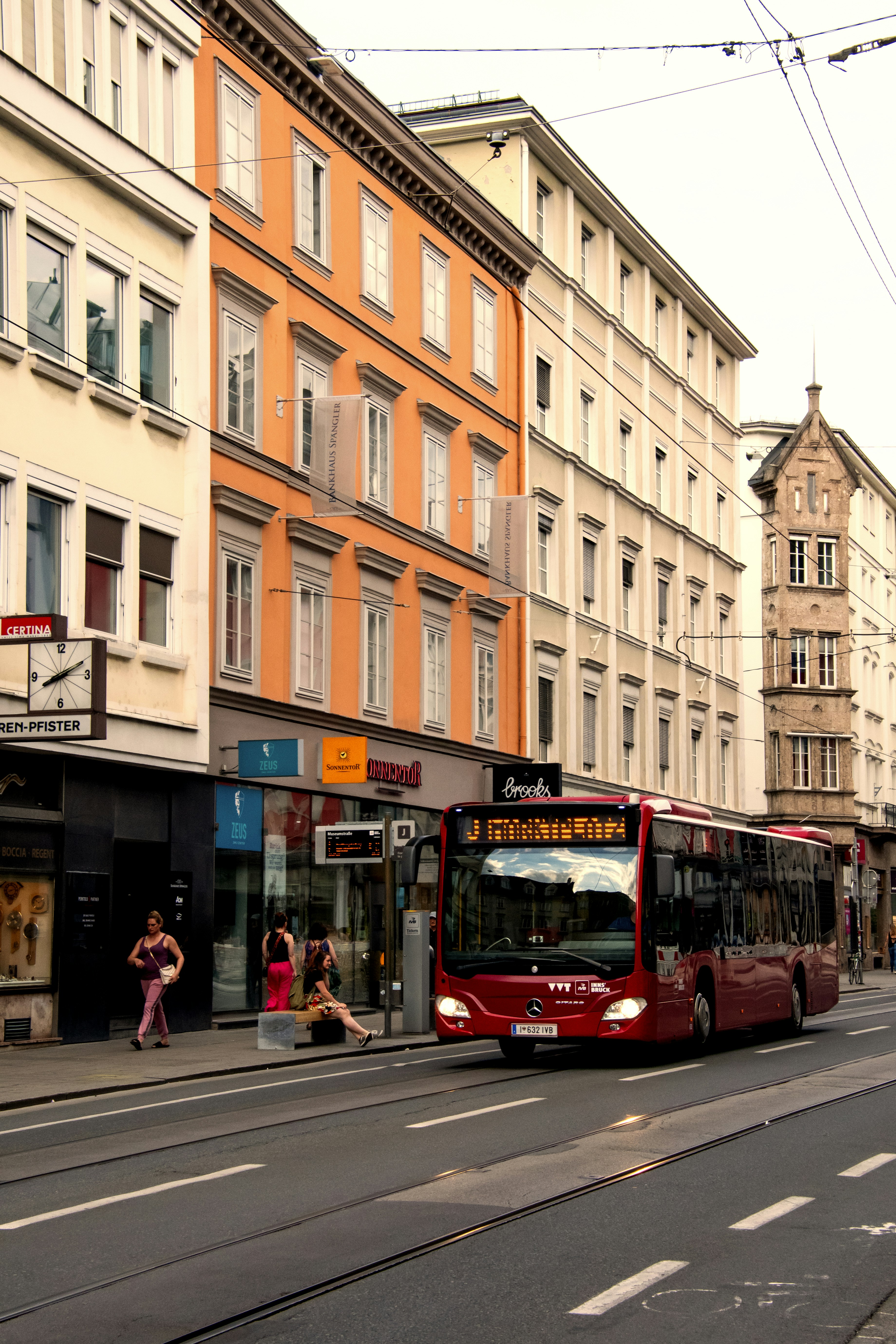 City Bus on a Warm Morning: A Lively Street Scene with Colorful Facades