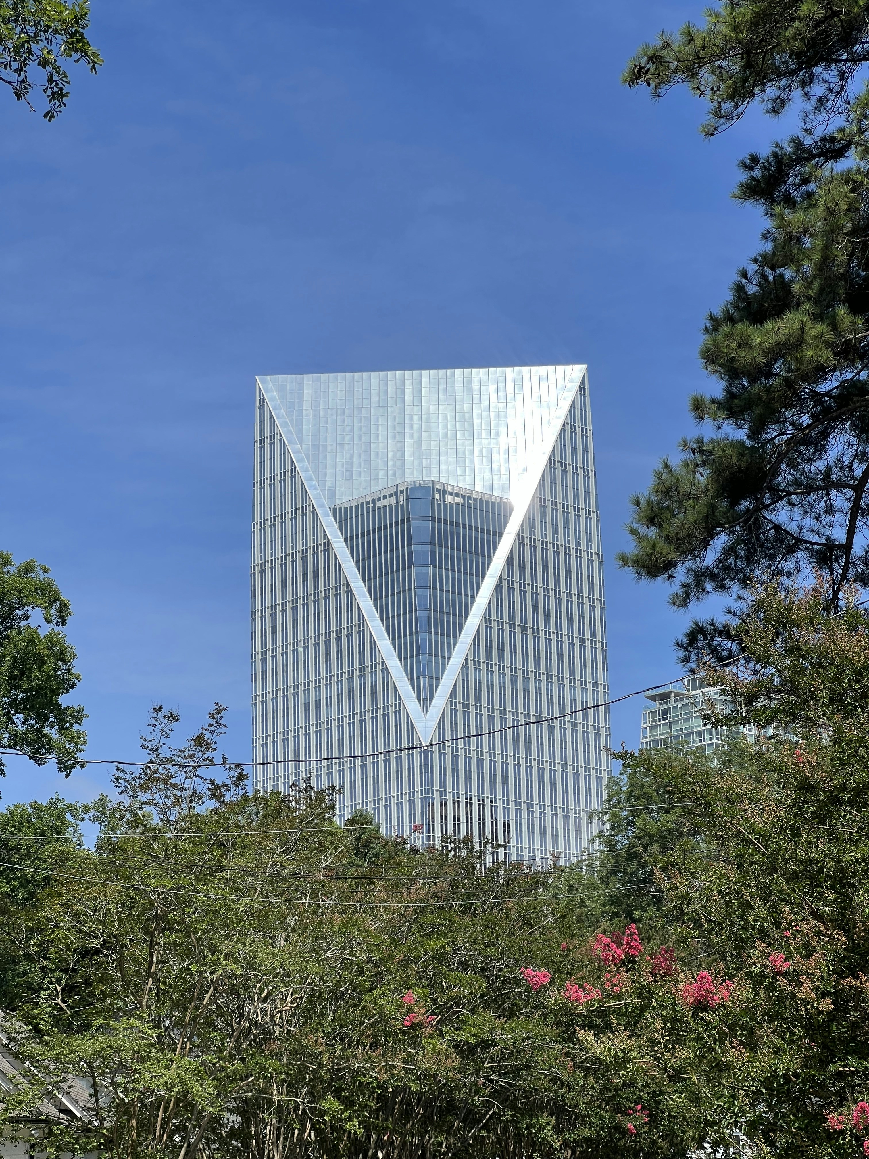 A very tall building with a triangular design on it's side photo – Free ...