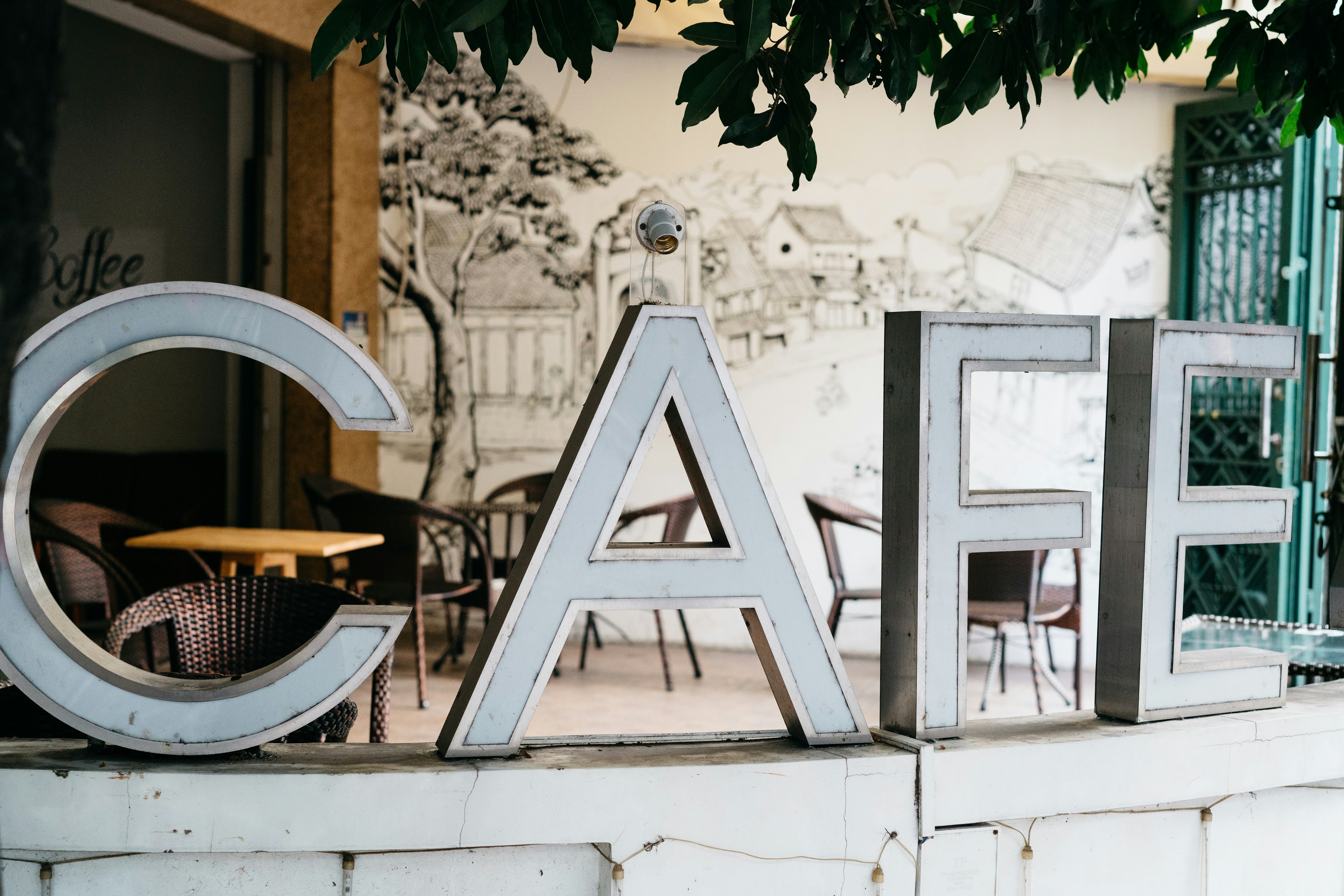 A sign that says cafe on the side of a building photo – Free Indoors ...