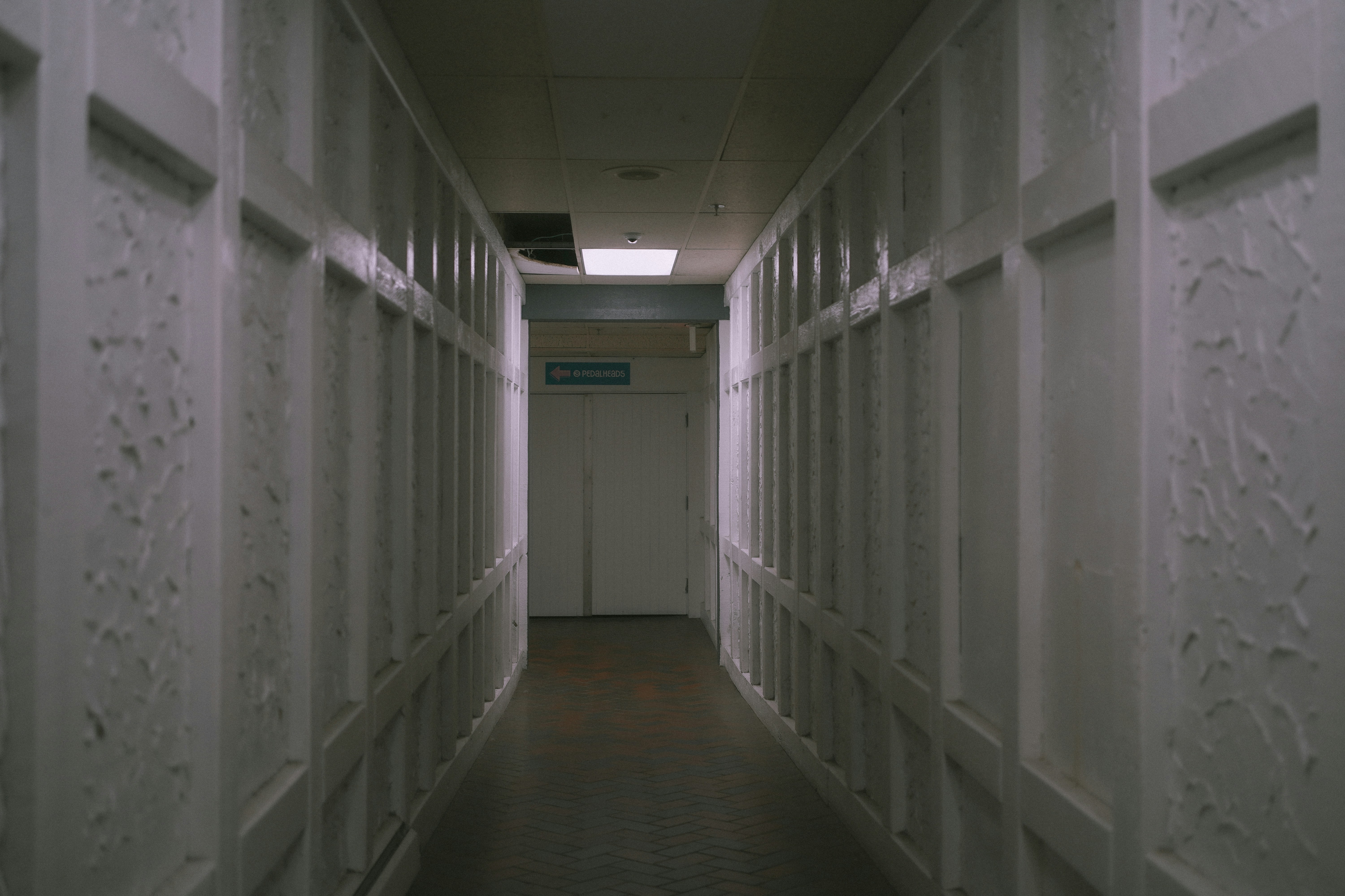 Foto zum Thema Ein langer Flur mit weißen Wänden und einem Schild an ...