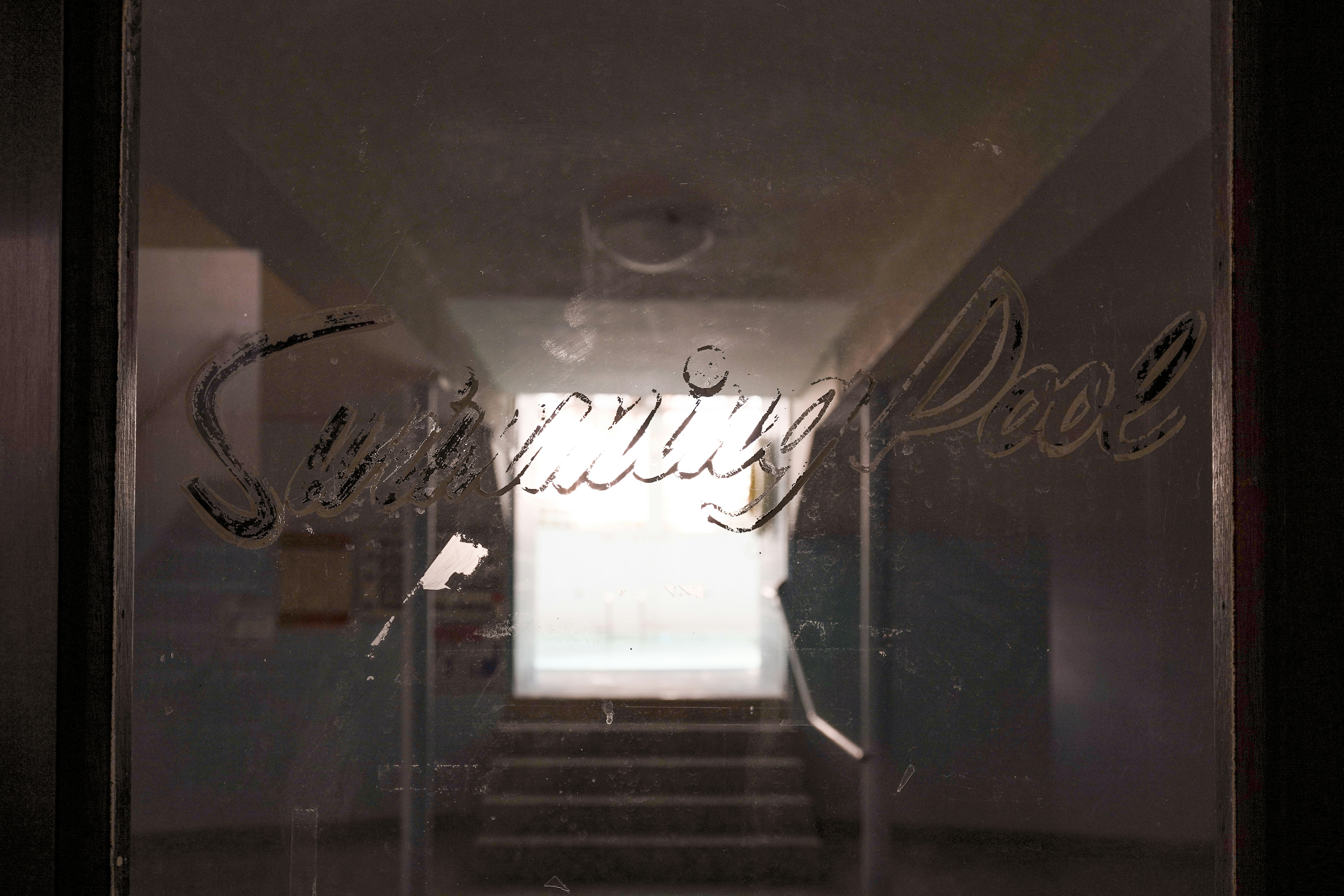 Foto Una vista de un pasillo a través de una puerta de vidrio – Imagen ...