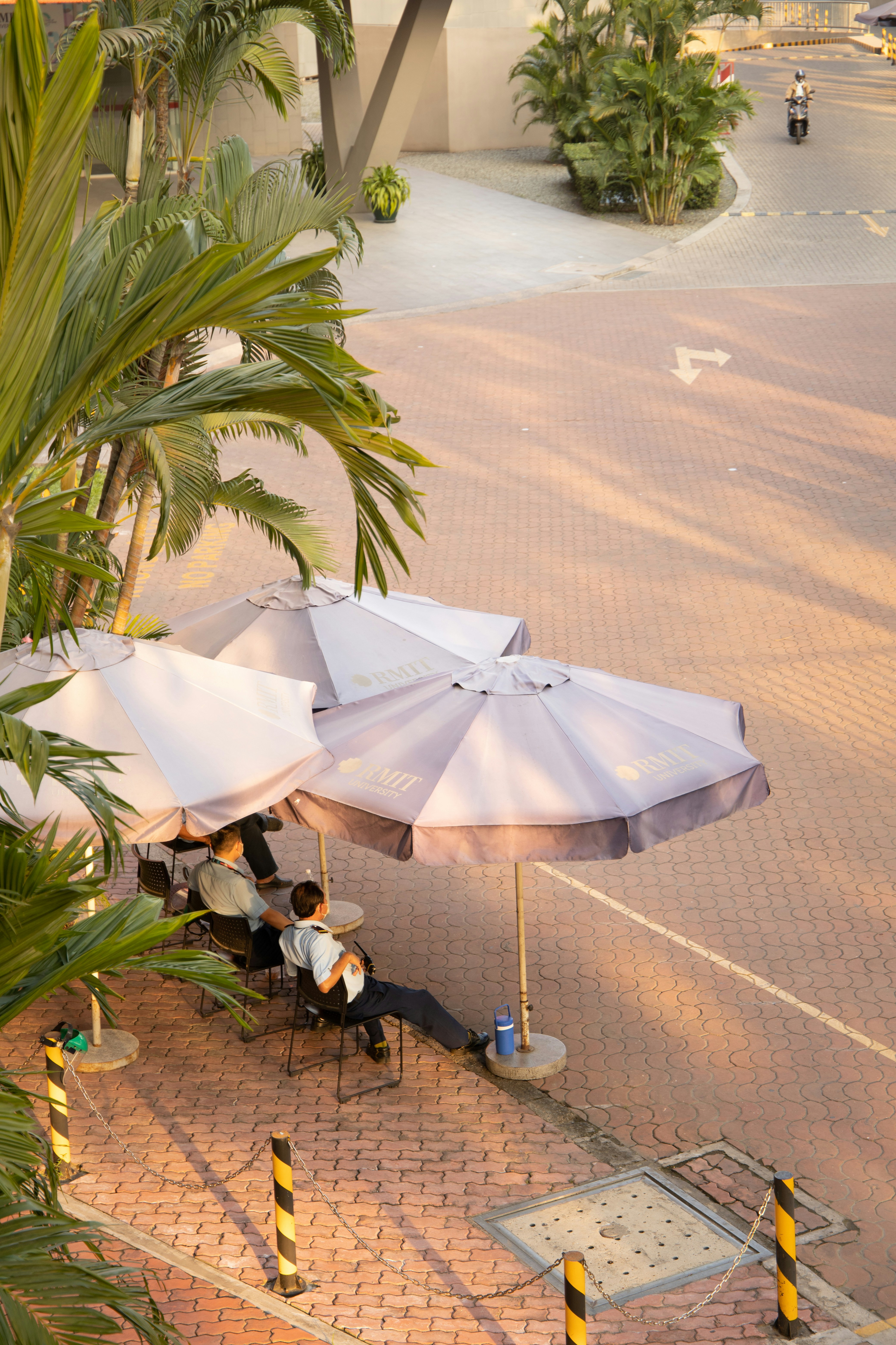 Shadows Under Umbrellas: Quiet Corner of a Brick Plaza