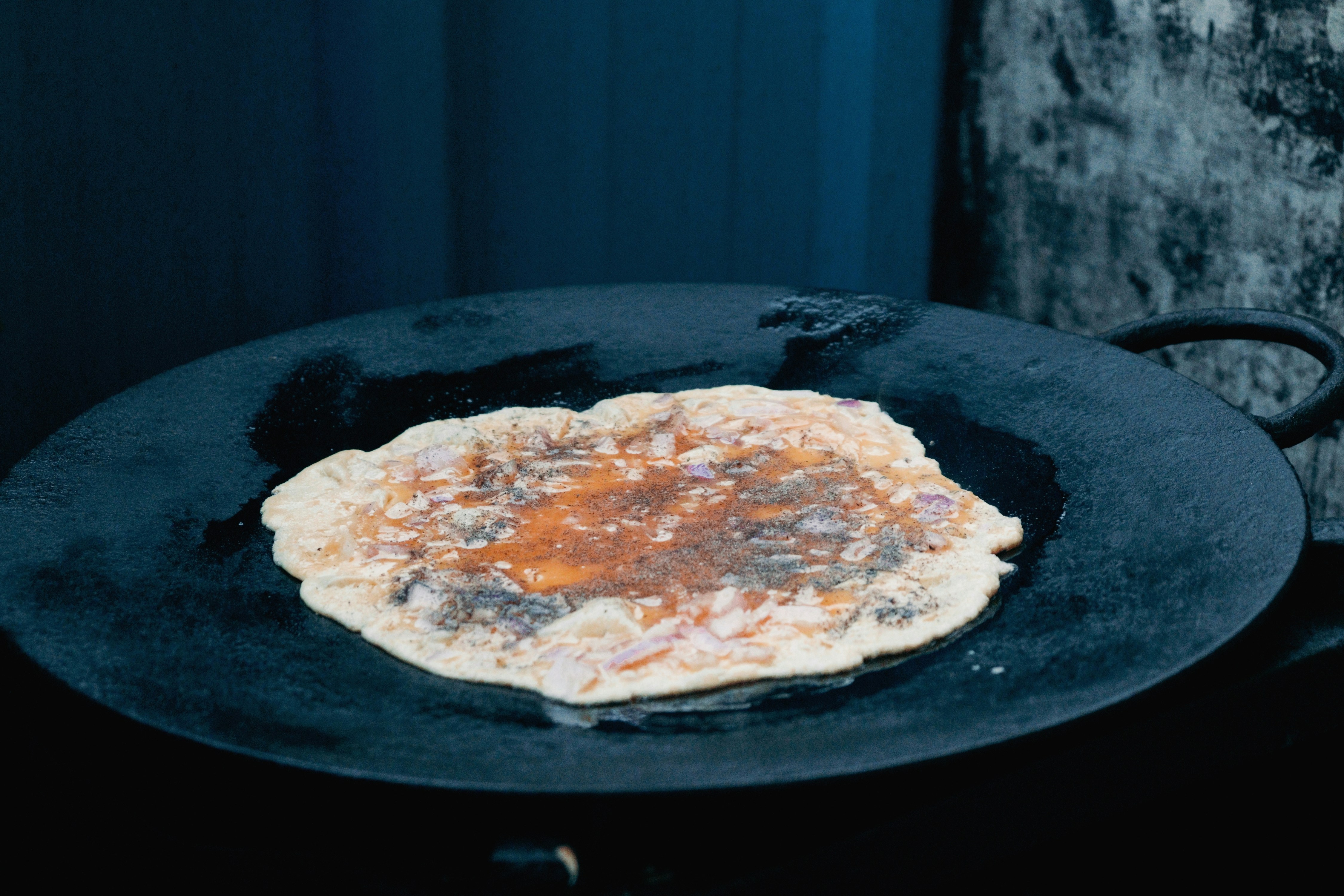 A pancake is being cooked in a cast iron skillet photo – Free Eggs ...