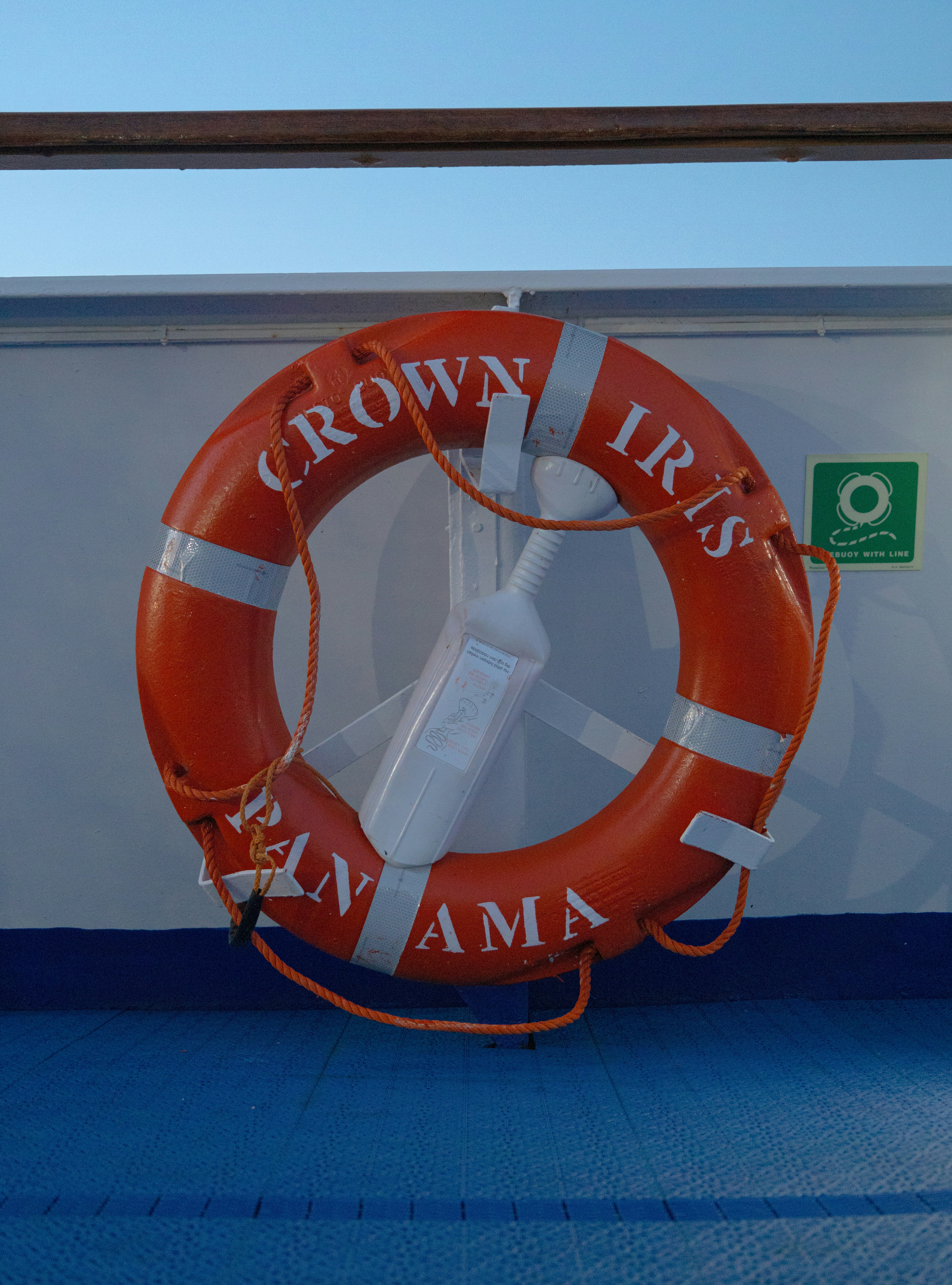 Orange Lifebuoy Framed by Blue Deck on a Vessel