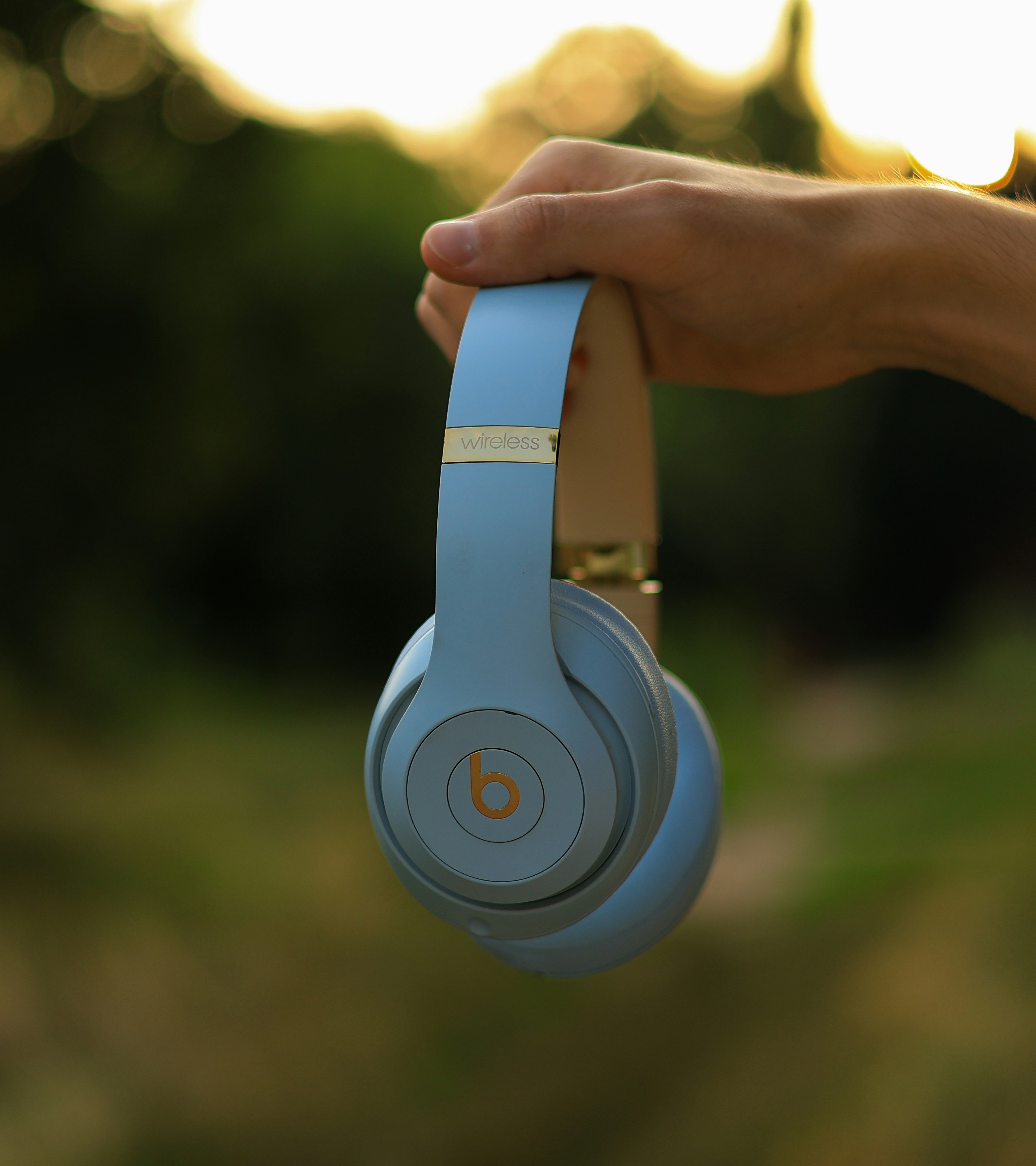 Blue Beats Headphones Dangling in a Golden Hour Park