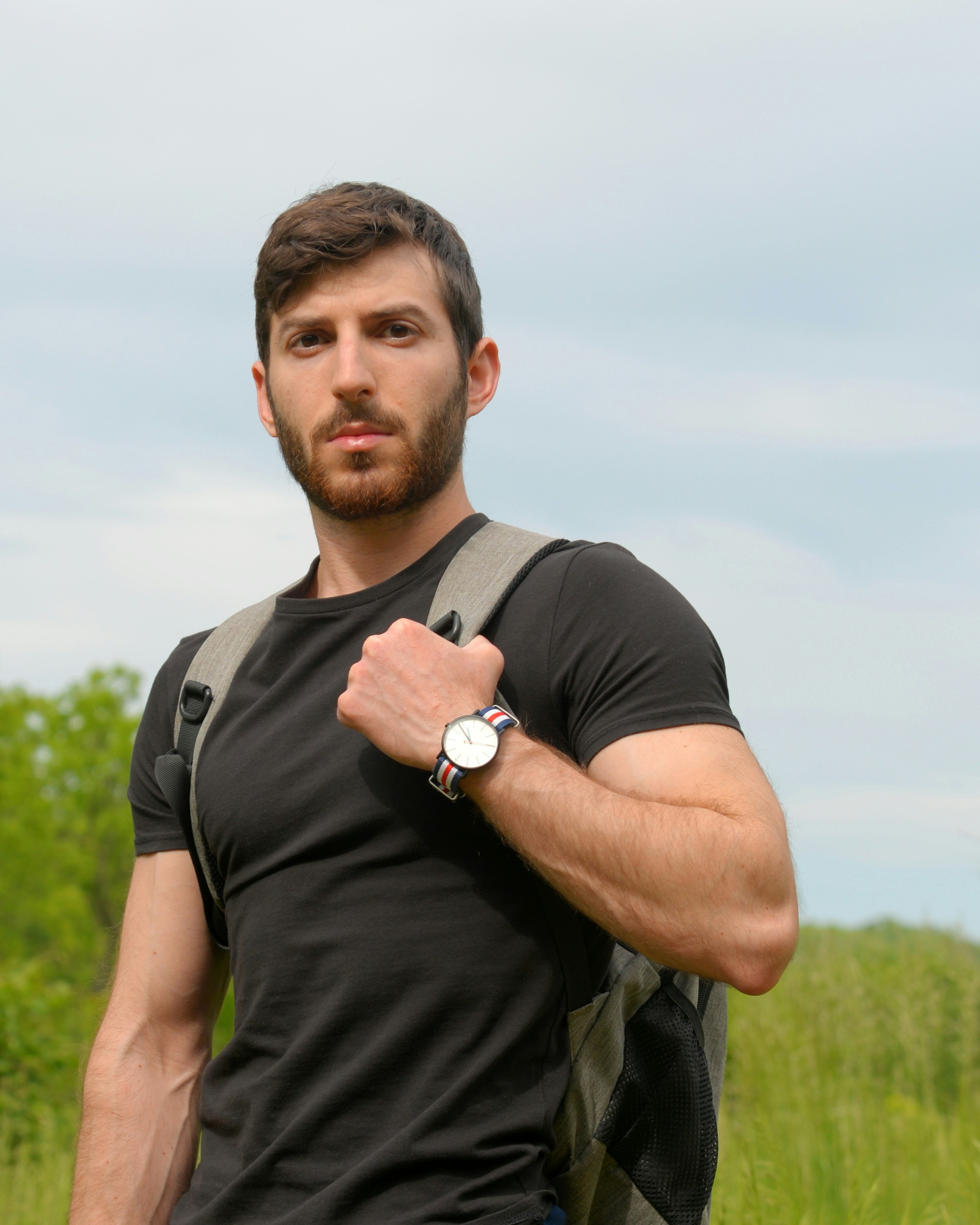 A man with a backpack and a watch on his wrist photo – Free Portrait ...