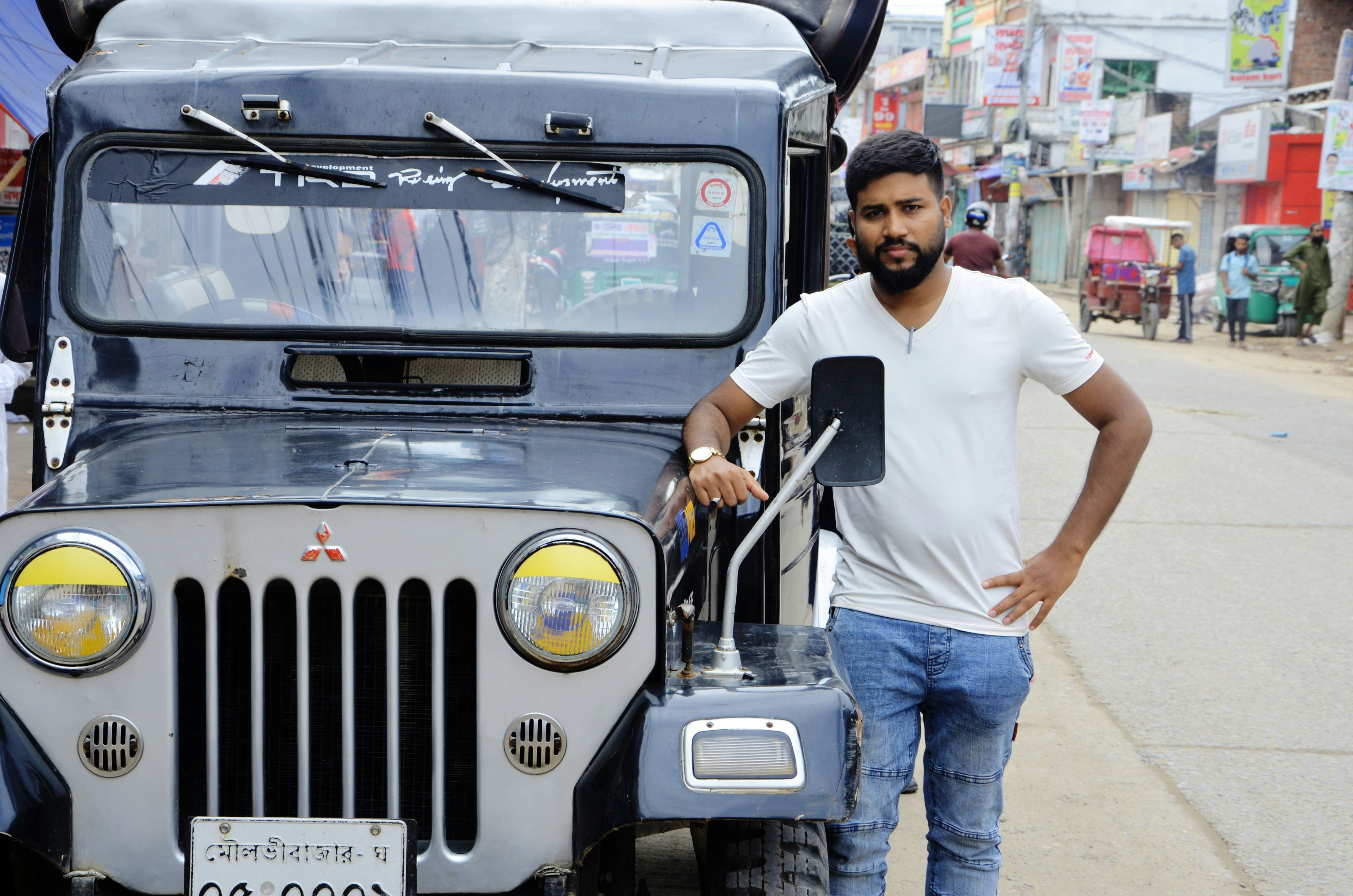 Portrait by a Weathered Jeep on a Sunlit Indian Avenue