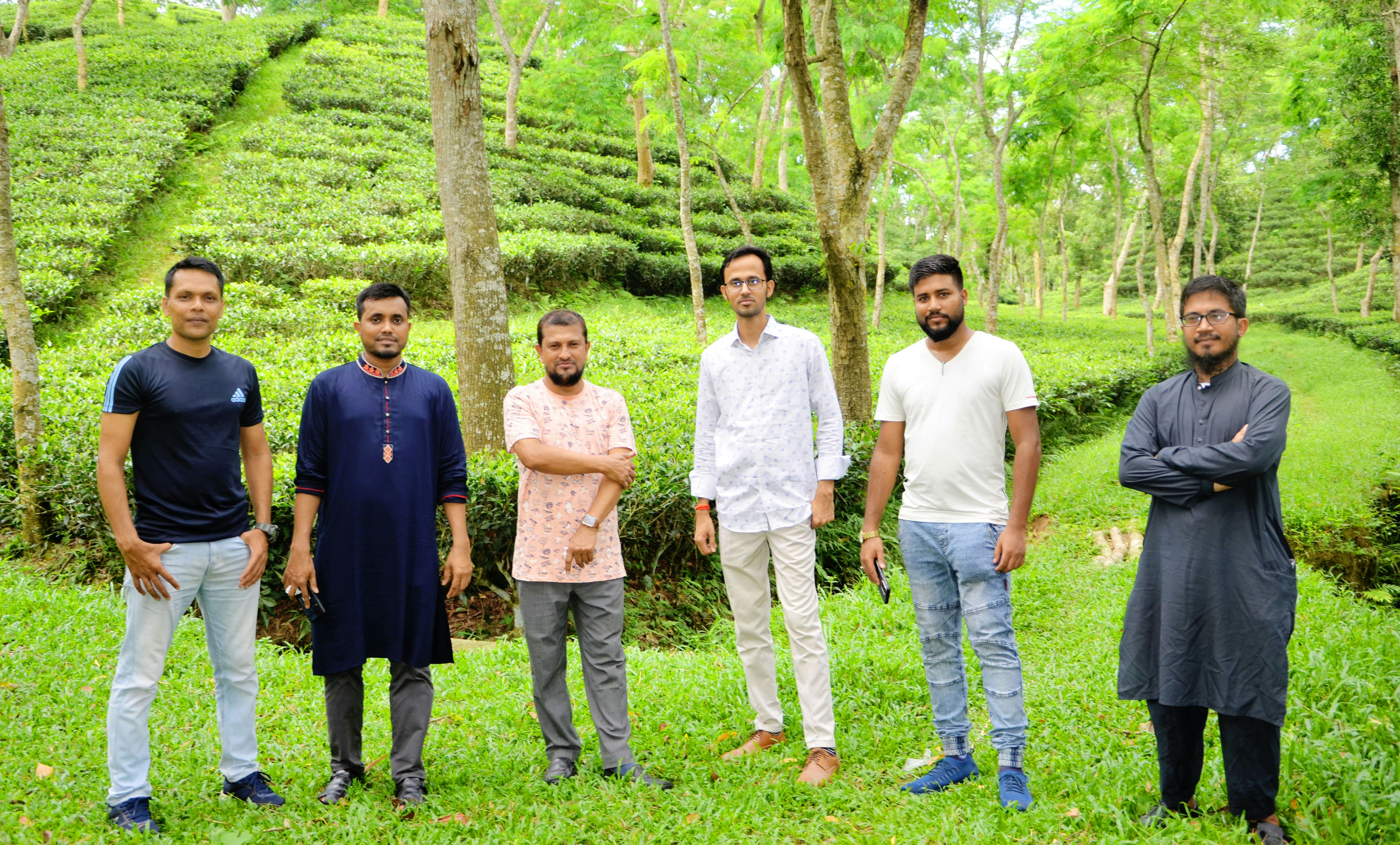 a group of men standing next to each other on a lush green field