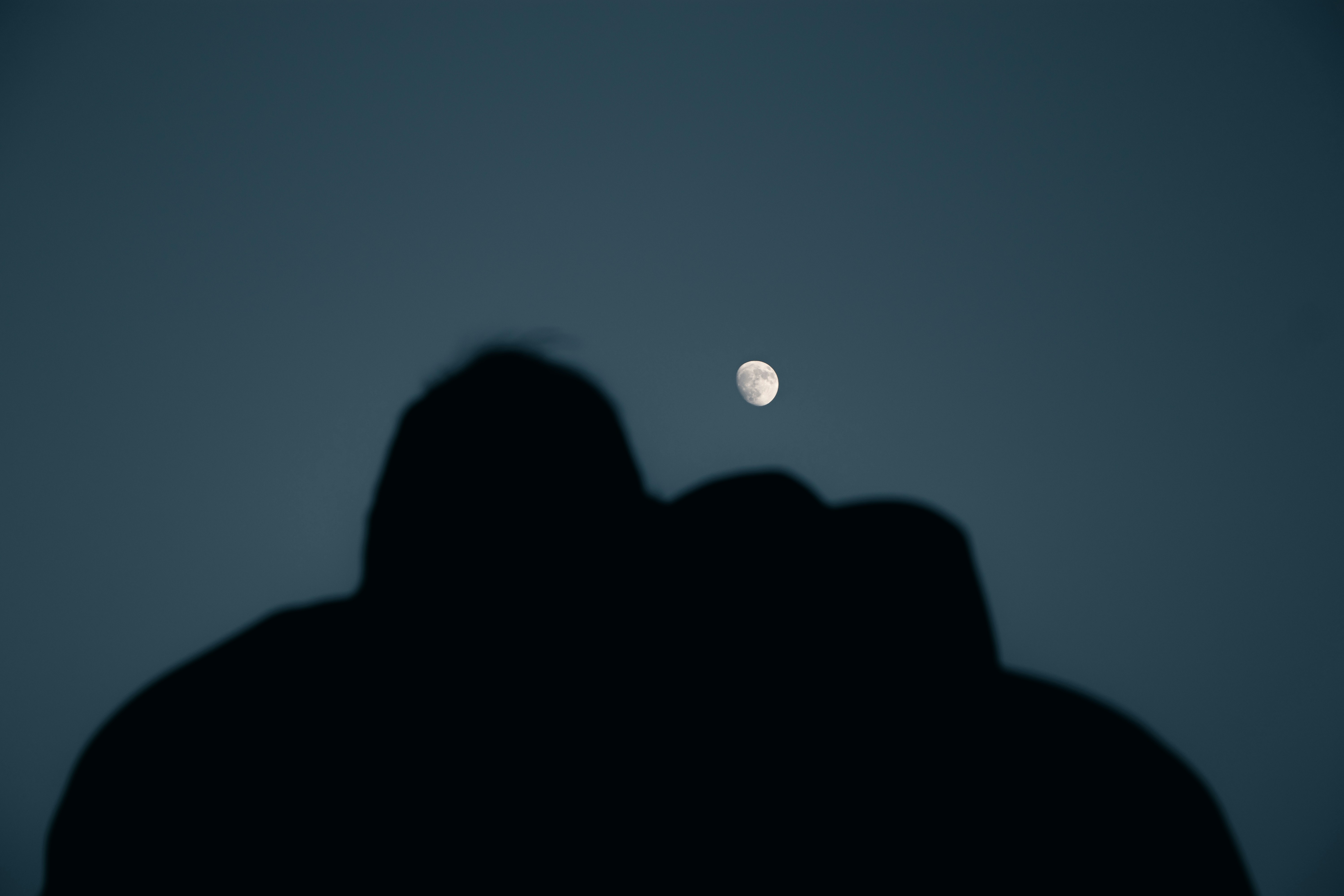 A silhouette of a person with the moon in the background photo – Free ...