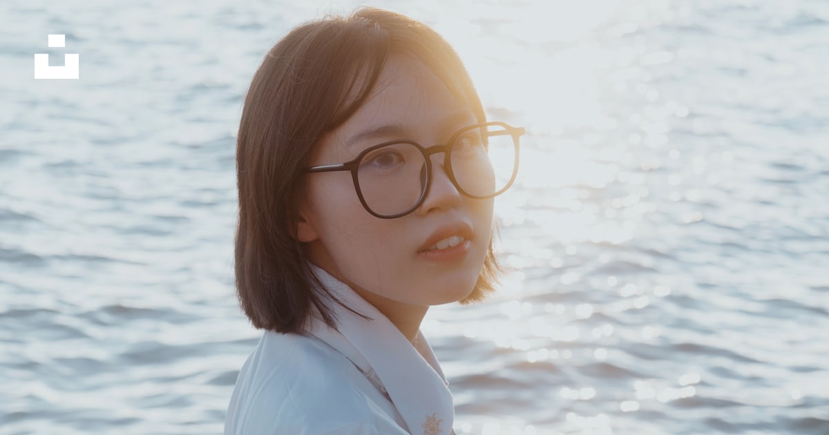 안경을 쓴 여자가 물줄기 옆에 서 있다 사진 Unsplash의 무료 블라우스 이미지