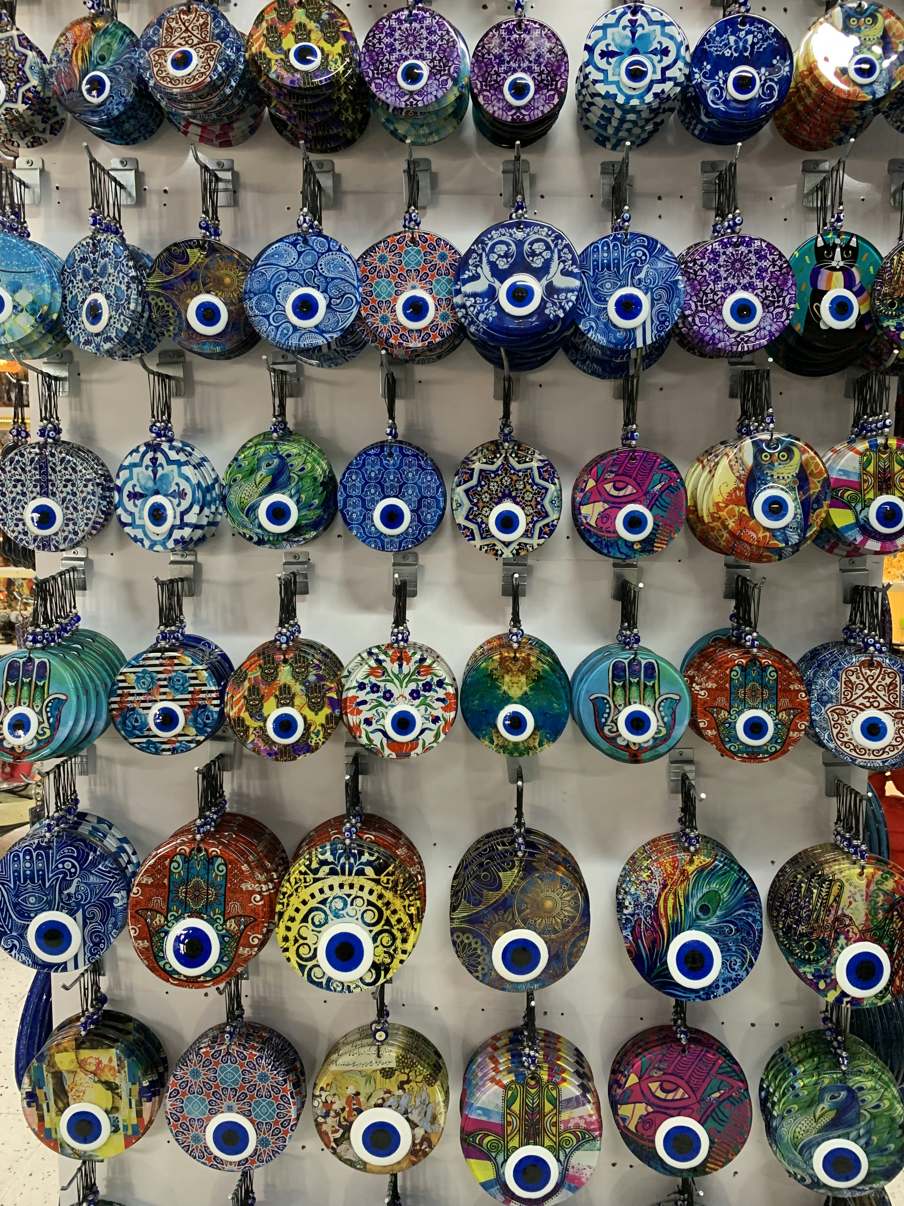 Carousel of Color: Hand-Painted Evil Eye Keychains in a vibrant shop display