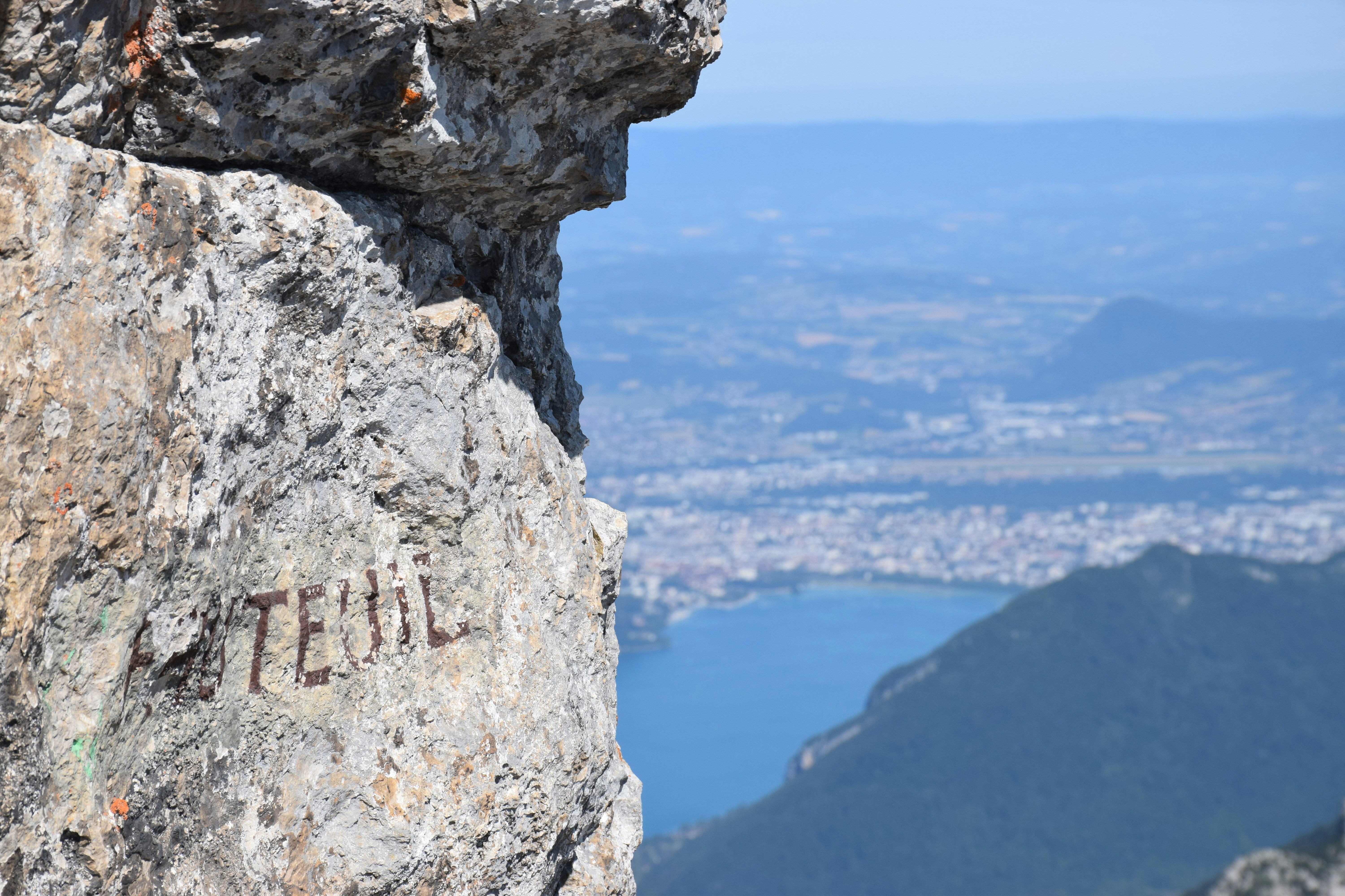 A rock with writing on it on top of a mountain photo – Free Annecy ...