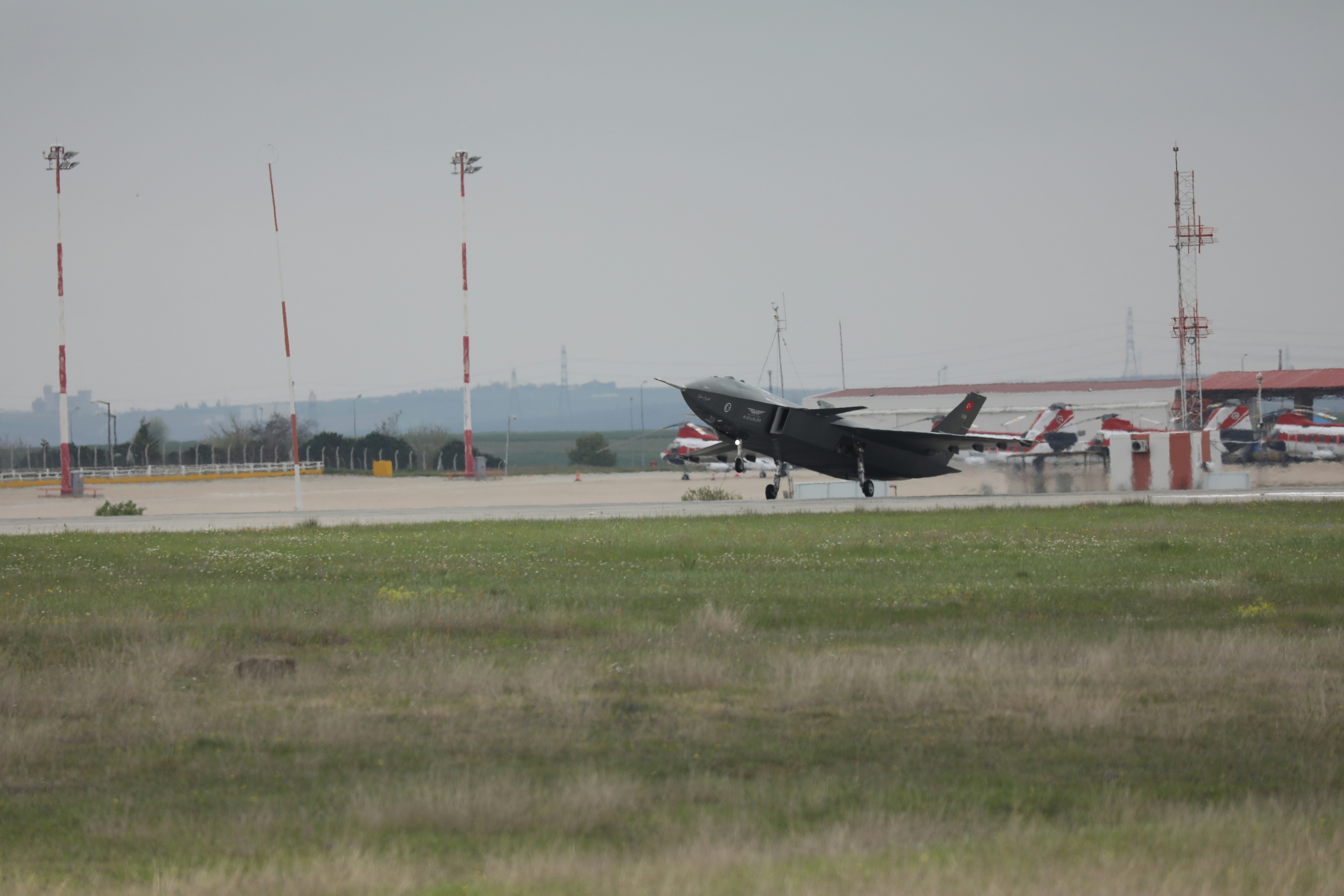 Midfield Silence: A Dark Fighter Taxis Across an Overcast Airfield