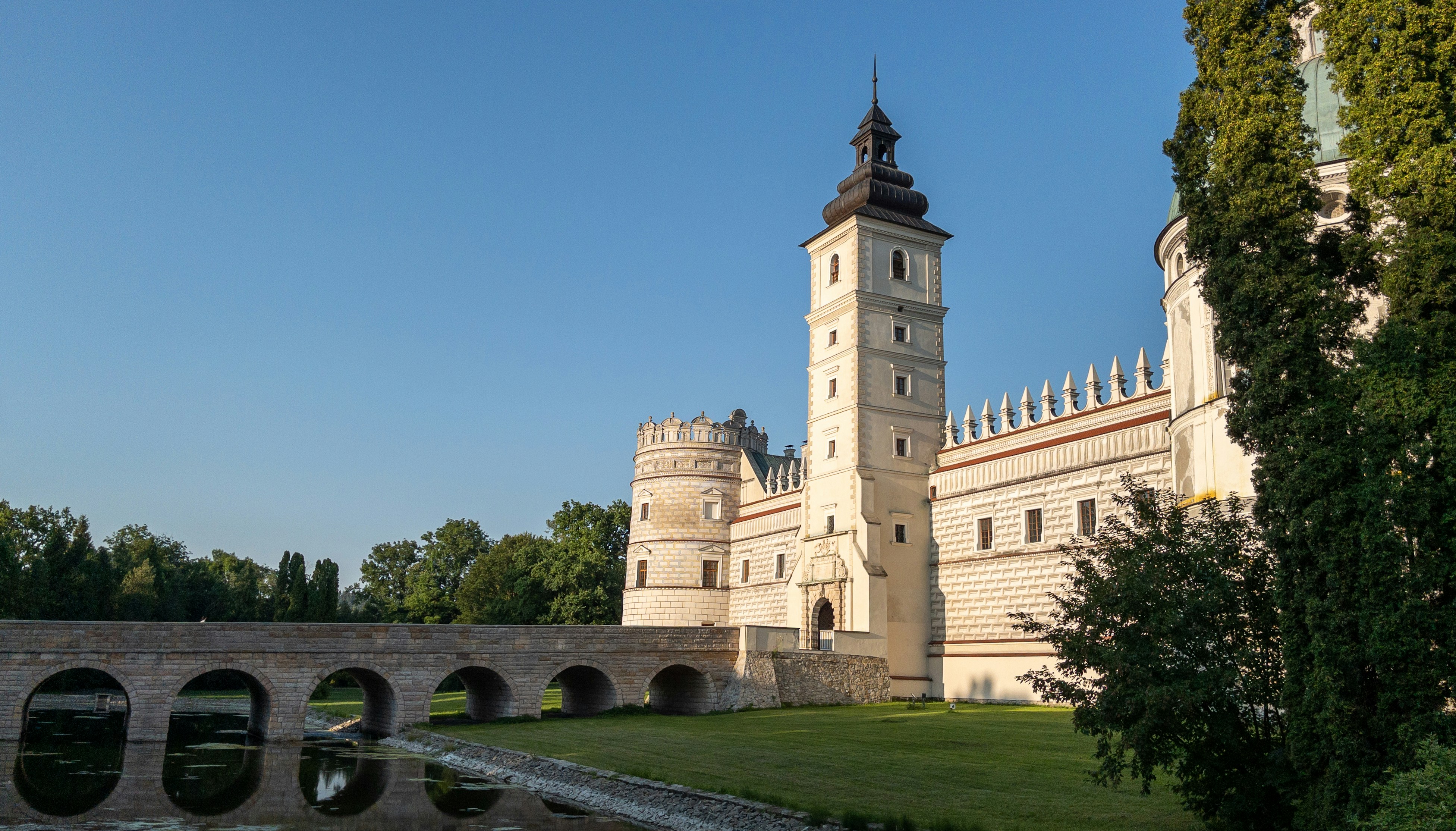 A large white castle with a bridge in front of it photo – Free Poland ...