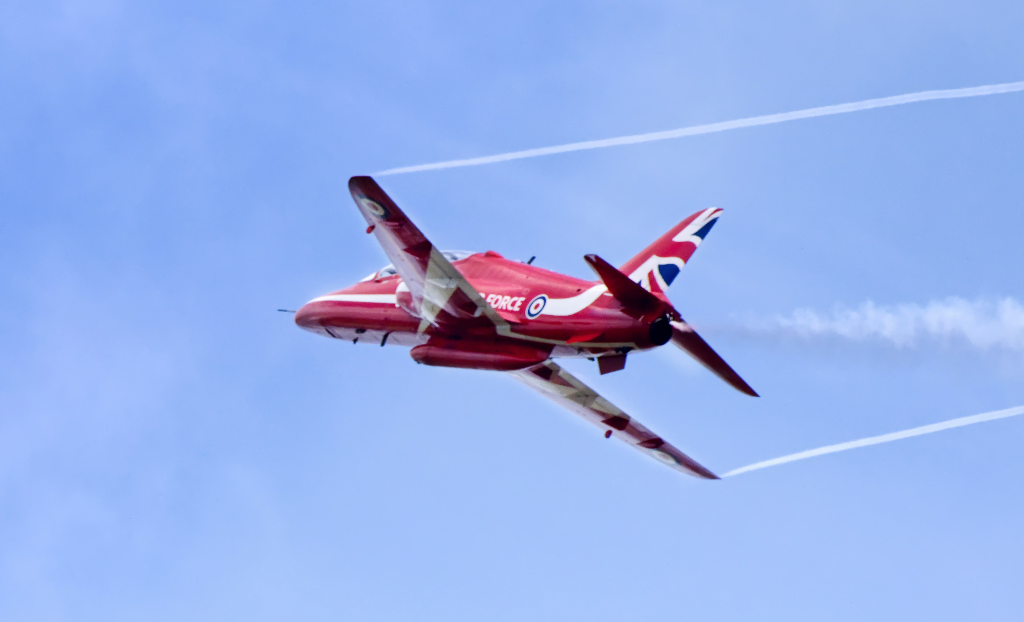 Un jet rouge et blanc volant dans un ciel bleu photo – Photo Royaume ...