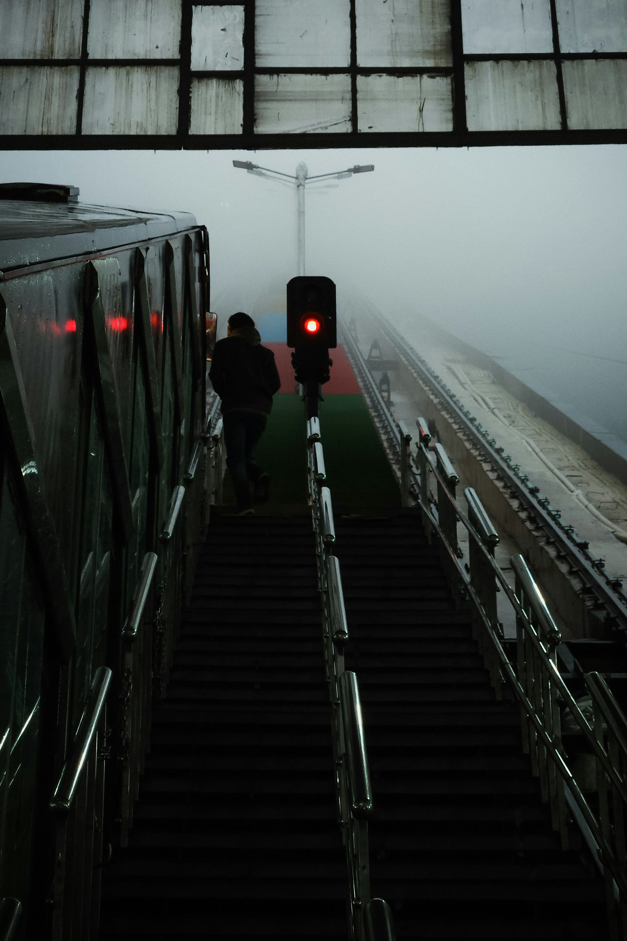 Red Signal on a Fogbound Staircase Leading to the Distant Rail