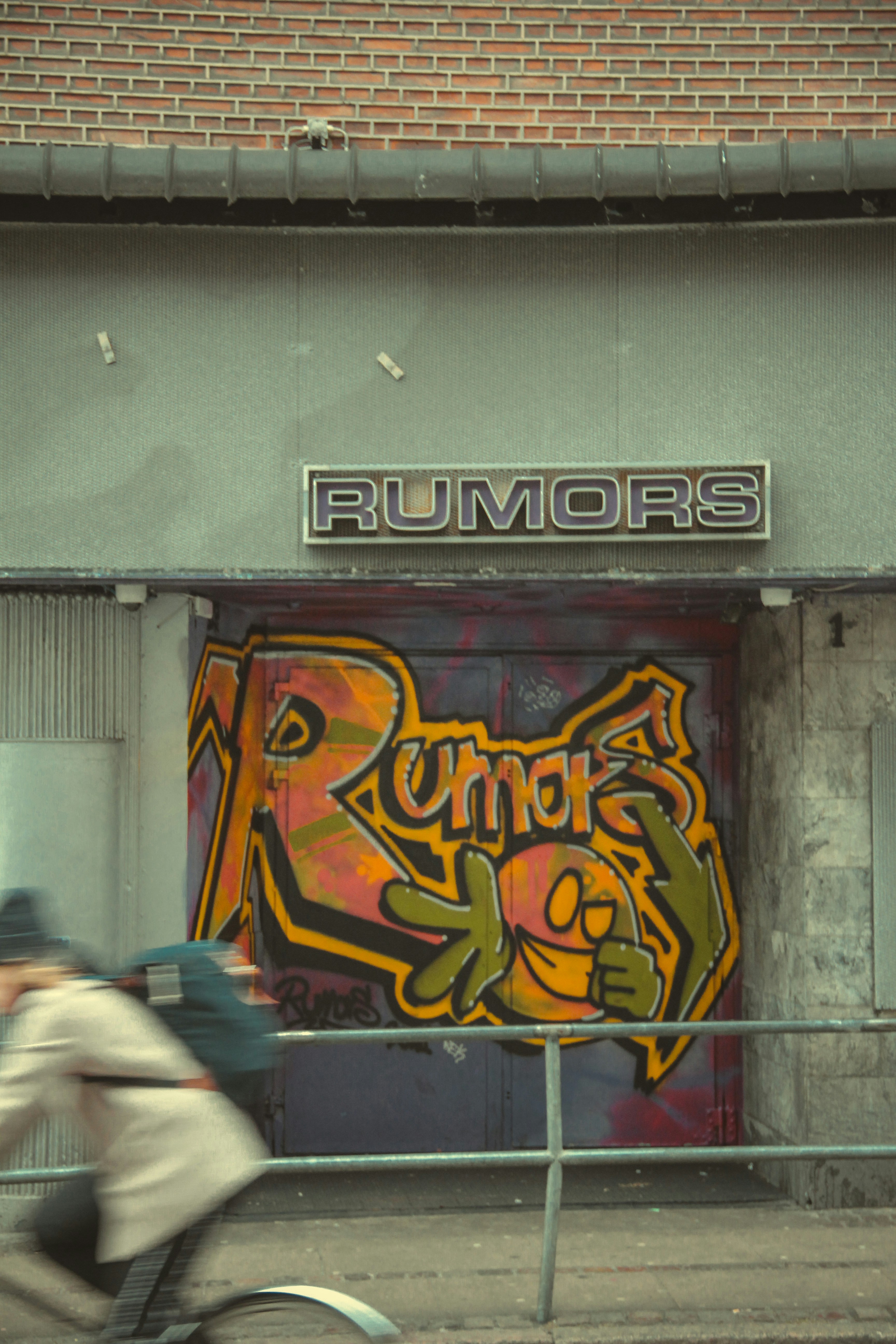 Rumors Under Neon Graffiti: A Colorful Door in Motion