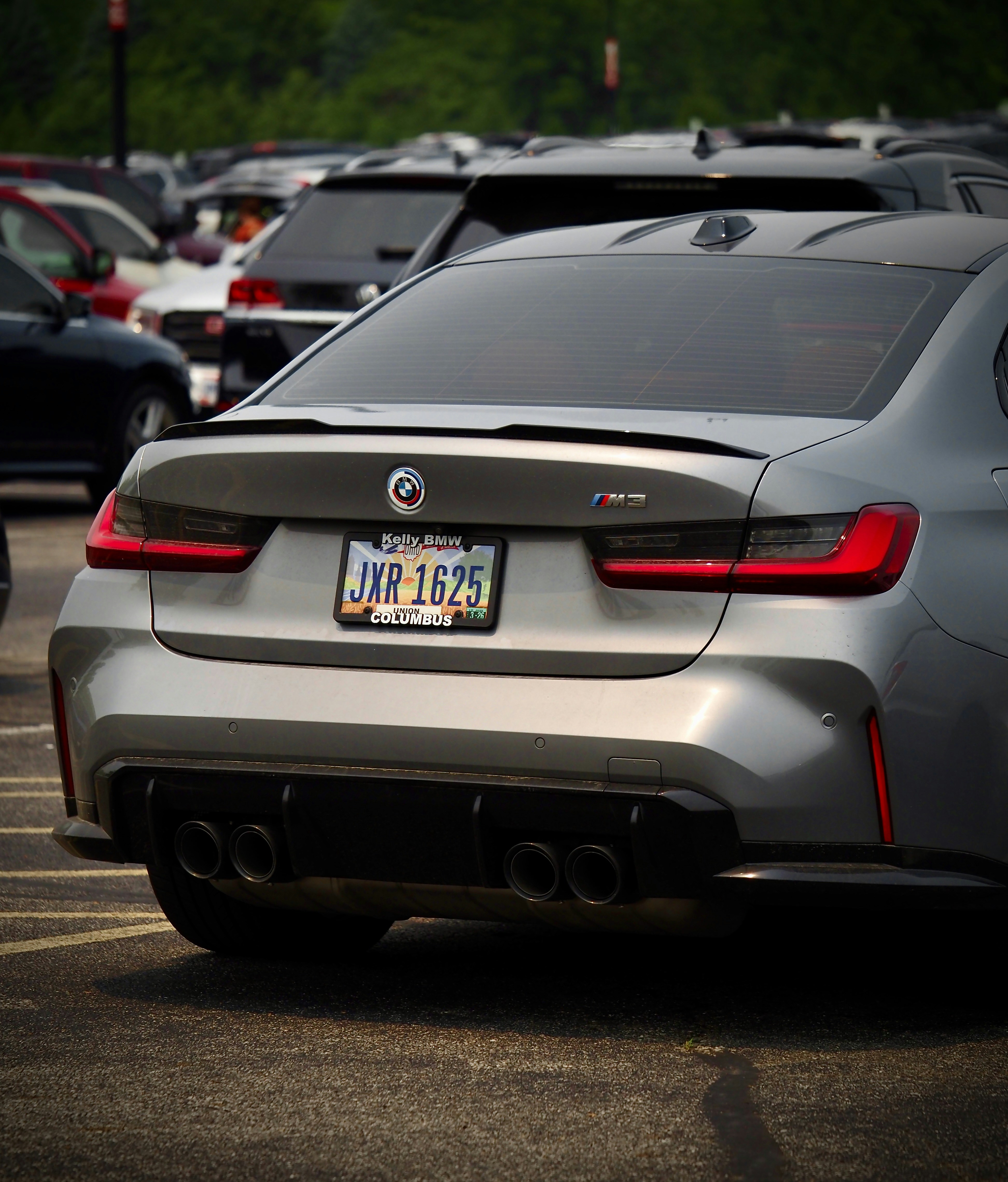 Rear-View Precision: Silver BMW M Series Surrounded by a Parking Lot Sea