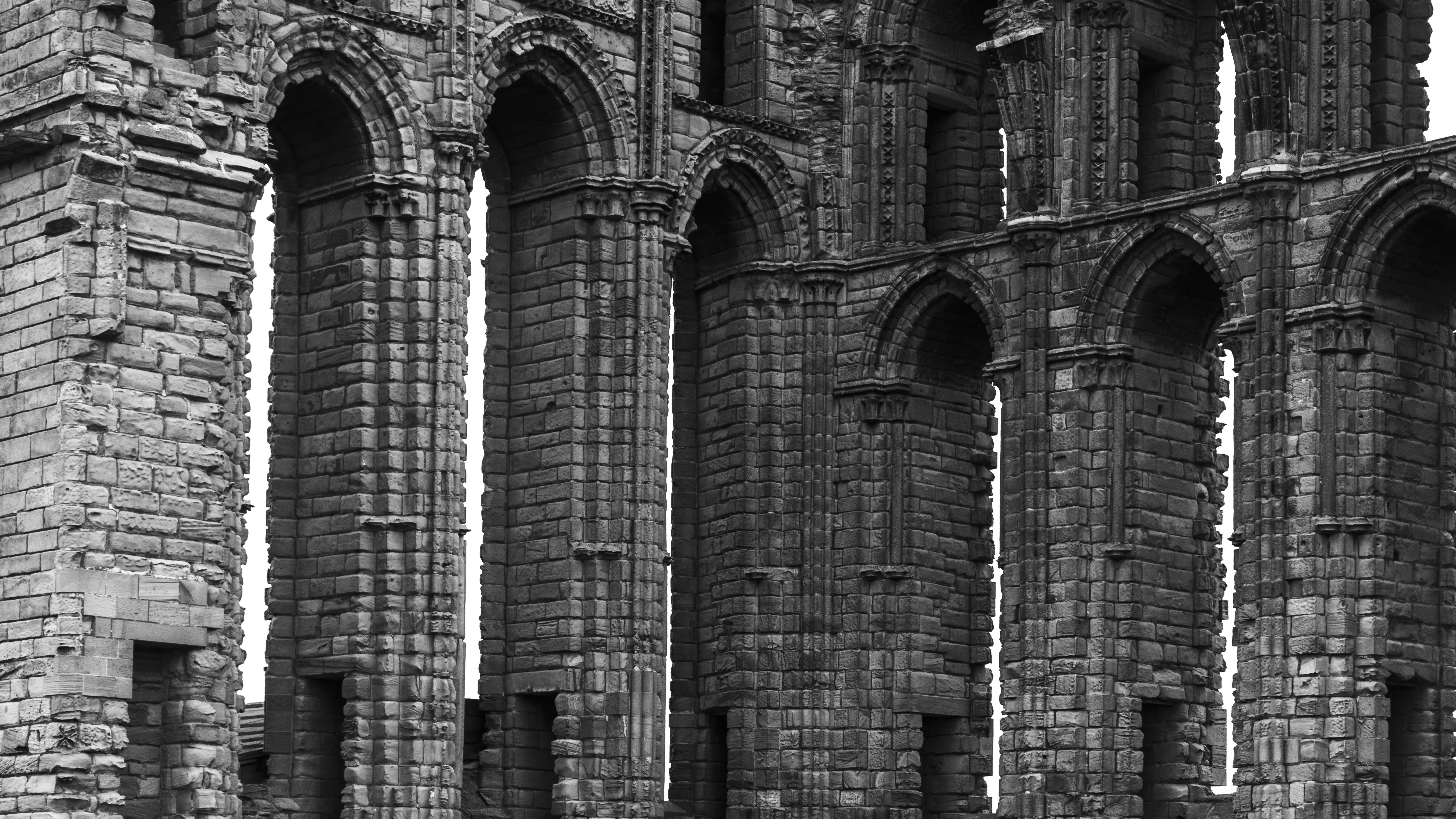 Black and white photo of ancient stone arches showcasing intricate Gothic architecture.