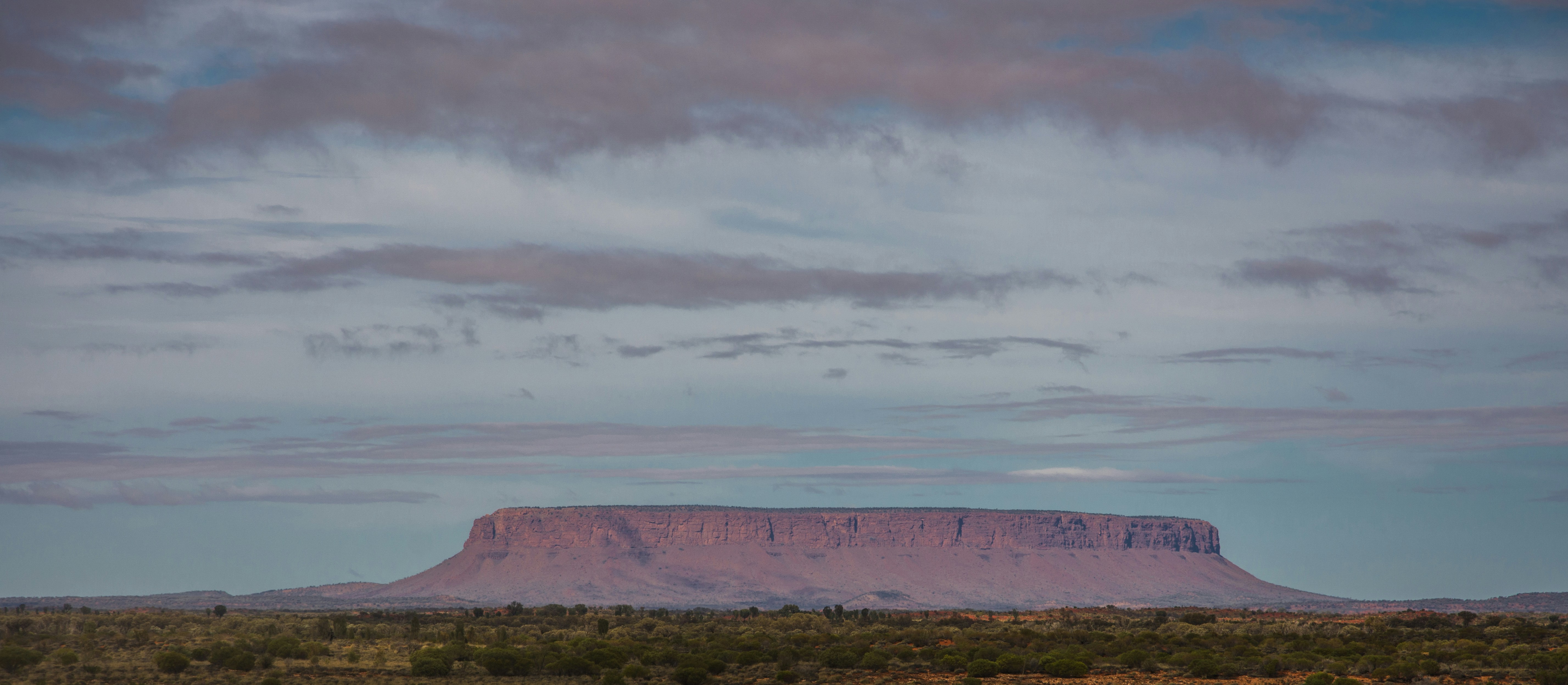 a large mountain in the distance under a cloudy skyDennis Mettler