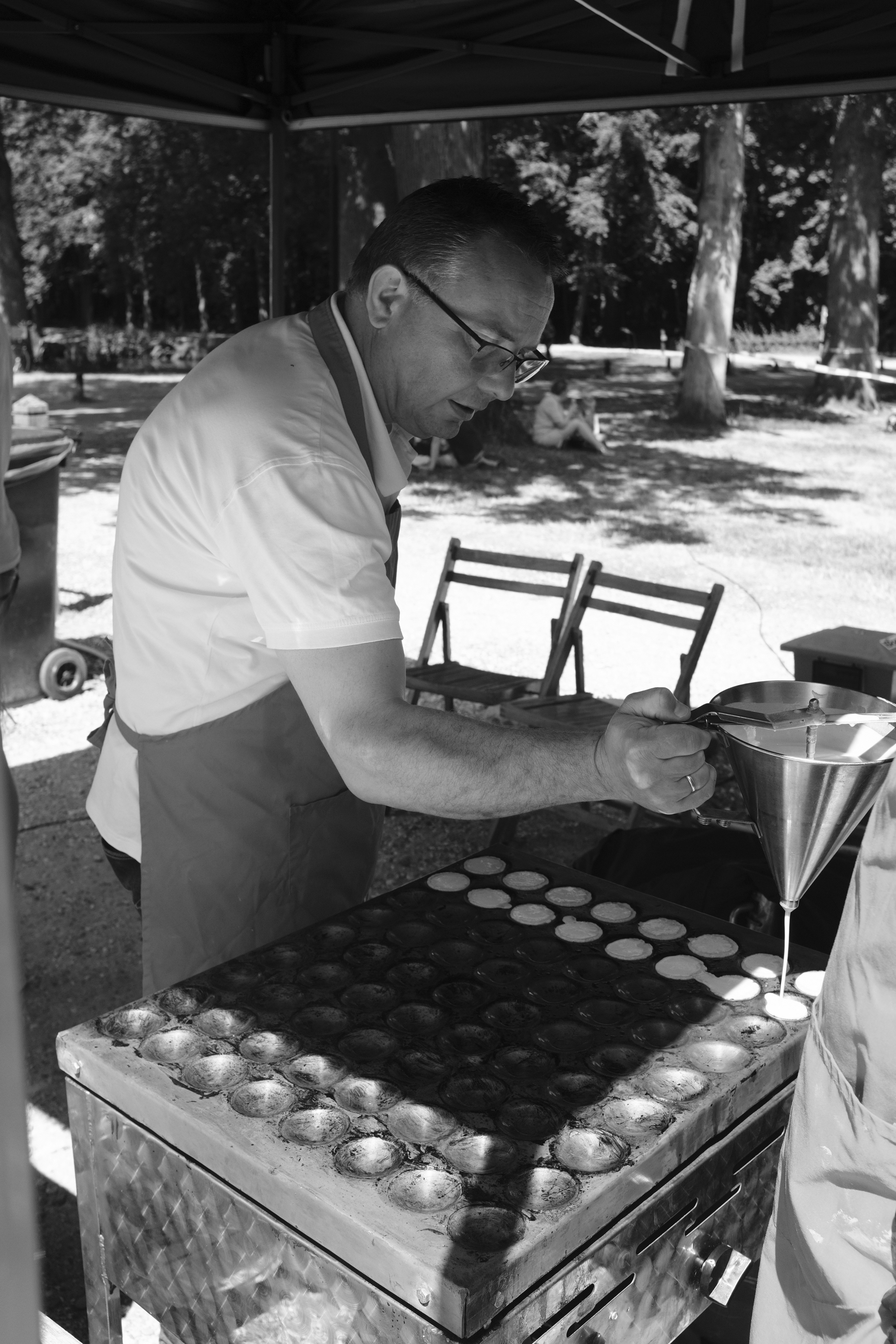 Une photo en noir et blanc d’un homme en train de faire des muffins ...