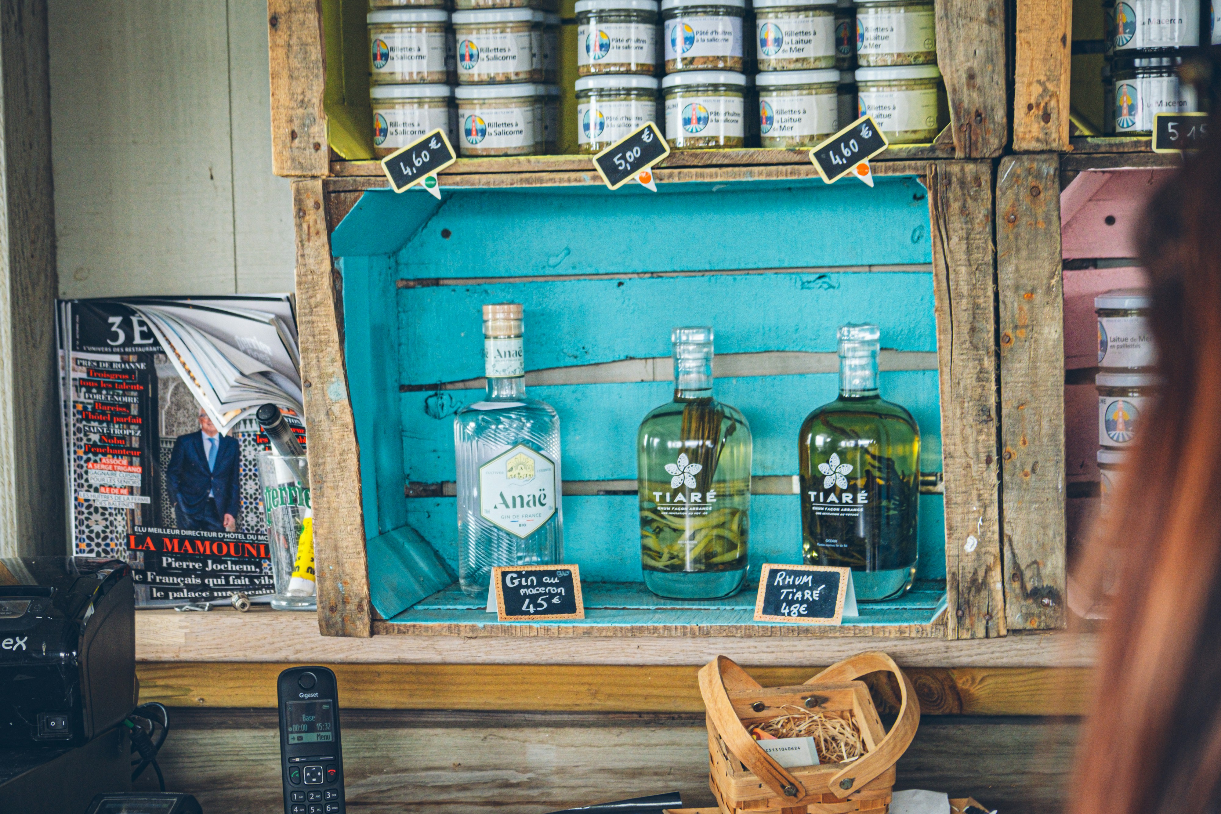 Turquoise display of bottled spirits behind rustic crates