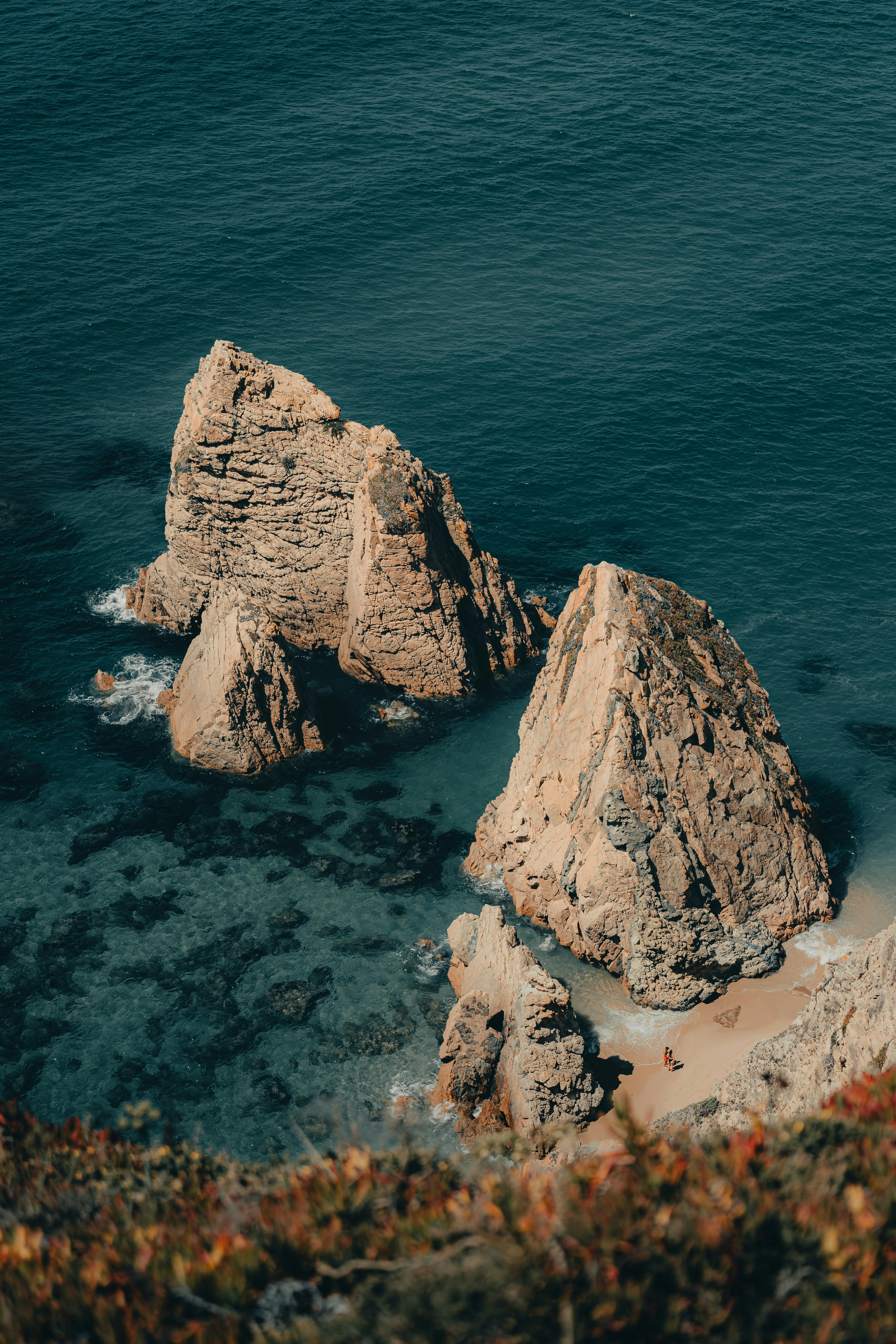 A couple of large rocks sitting on top of a beach photo – Free Nature ...