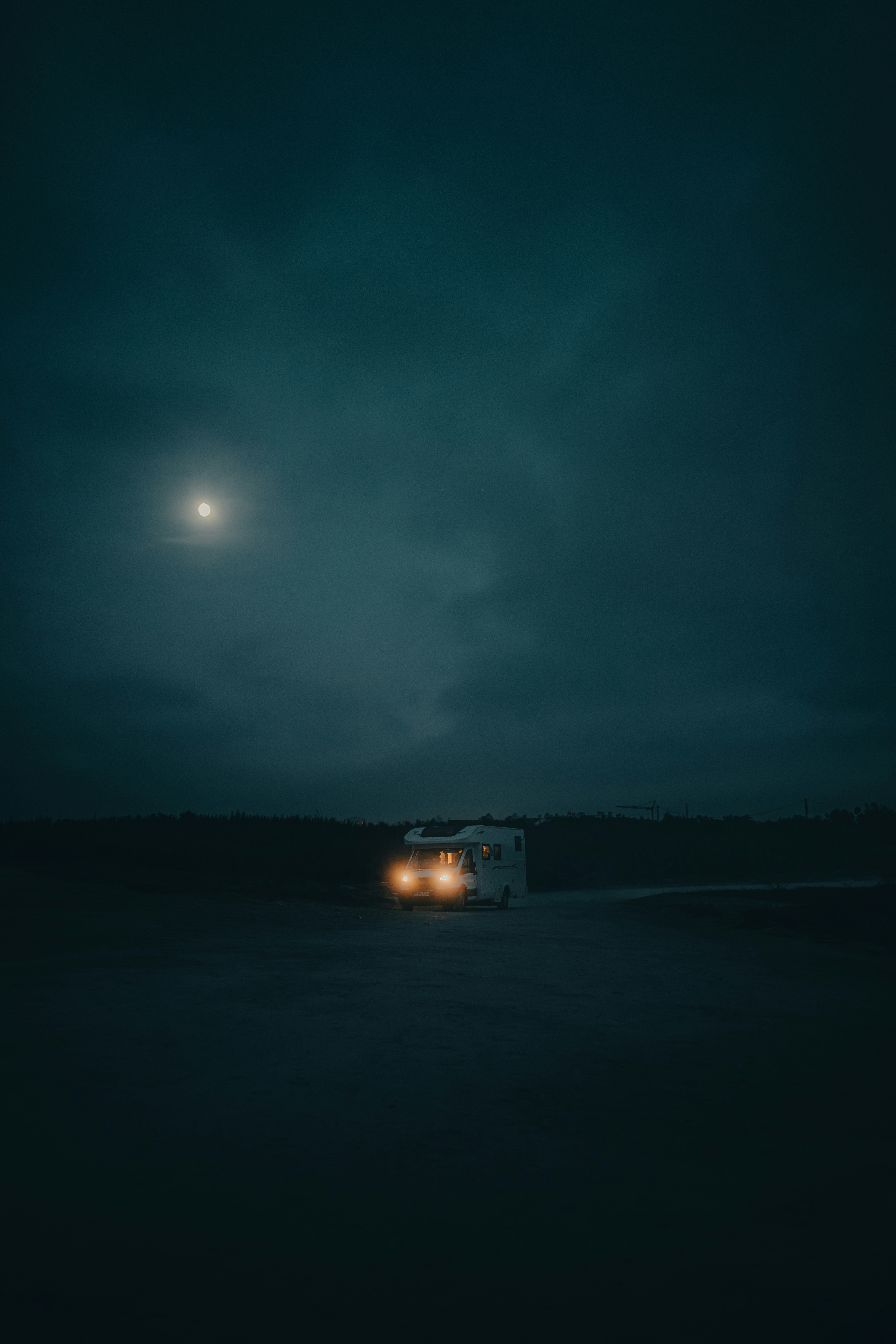 Moonlit Caravan on a Desolate Shore Under a Clouded Sky