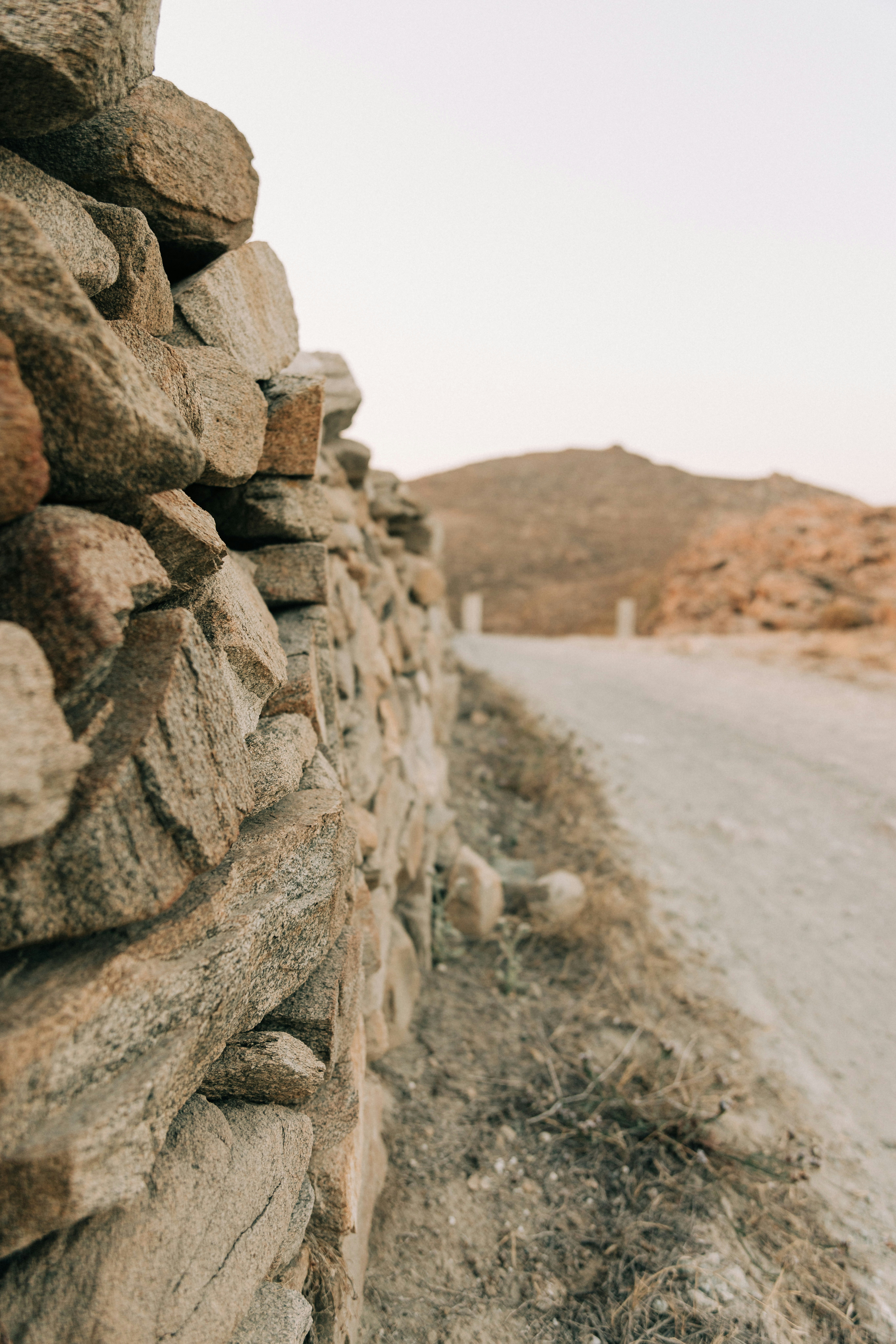 A stone wall next to a dirt road photo – Free Paros Image on Unsplash