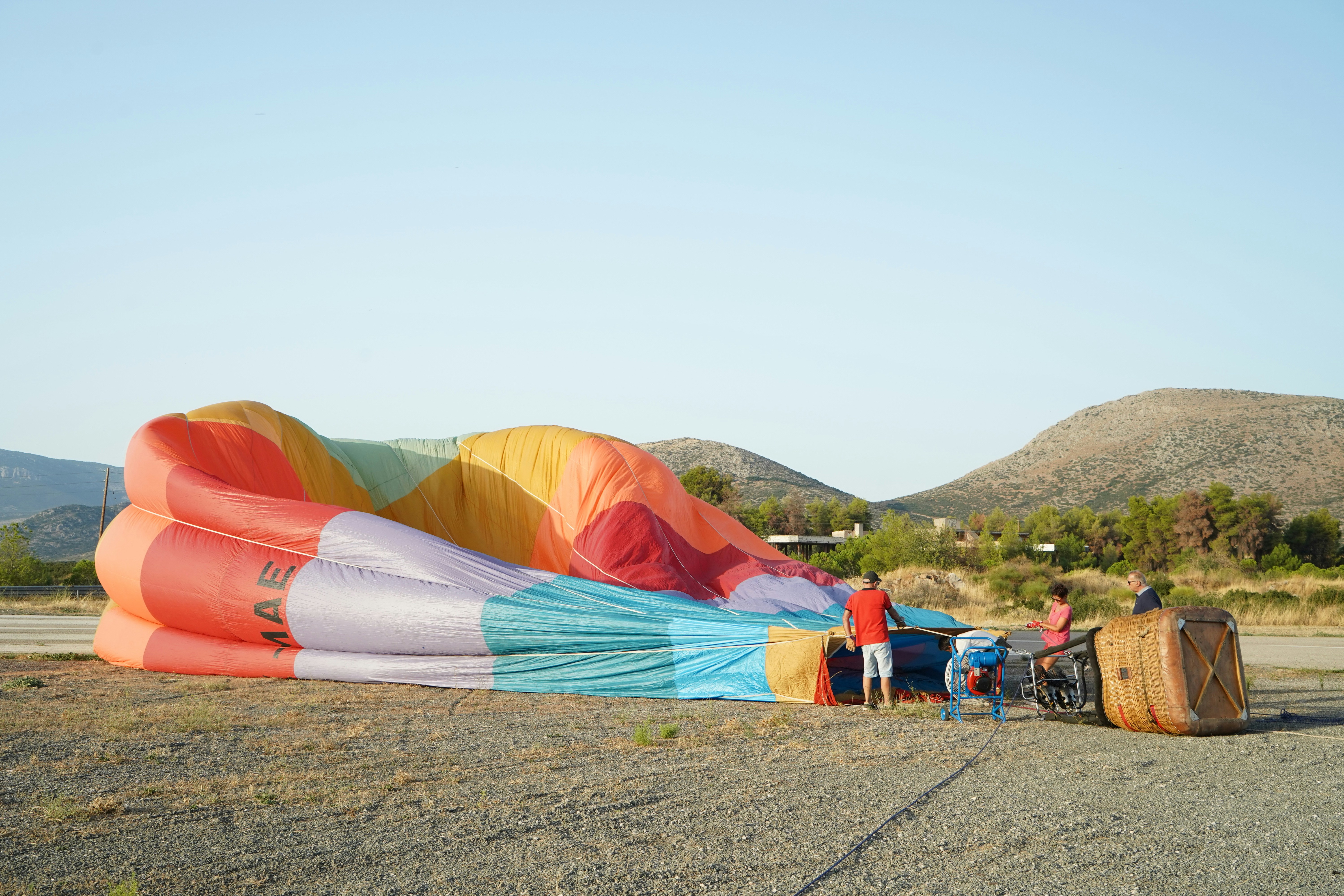 Palette on the Field: Preparing a Multicolored Balloon Under a Clear Sky