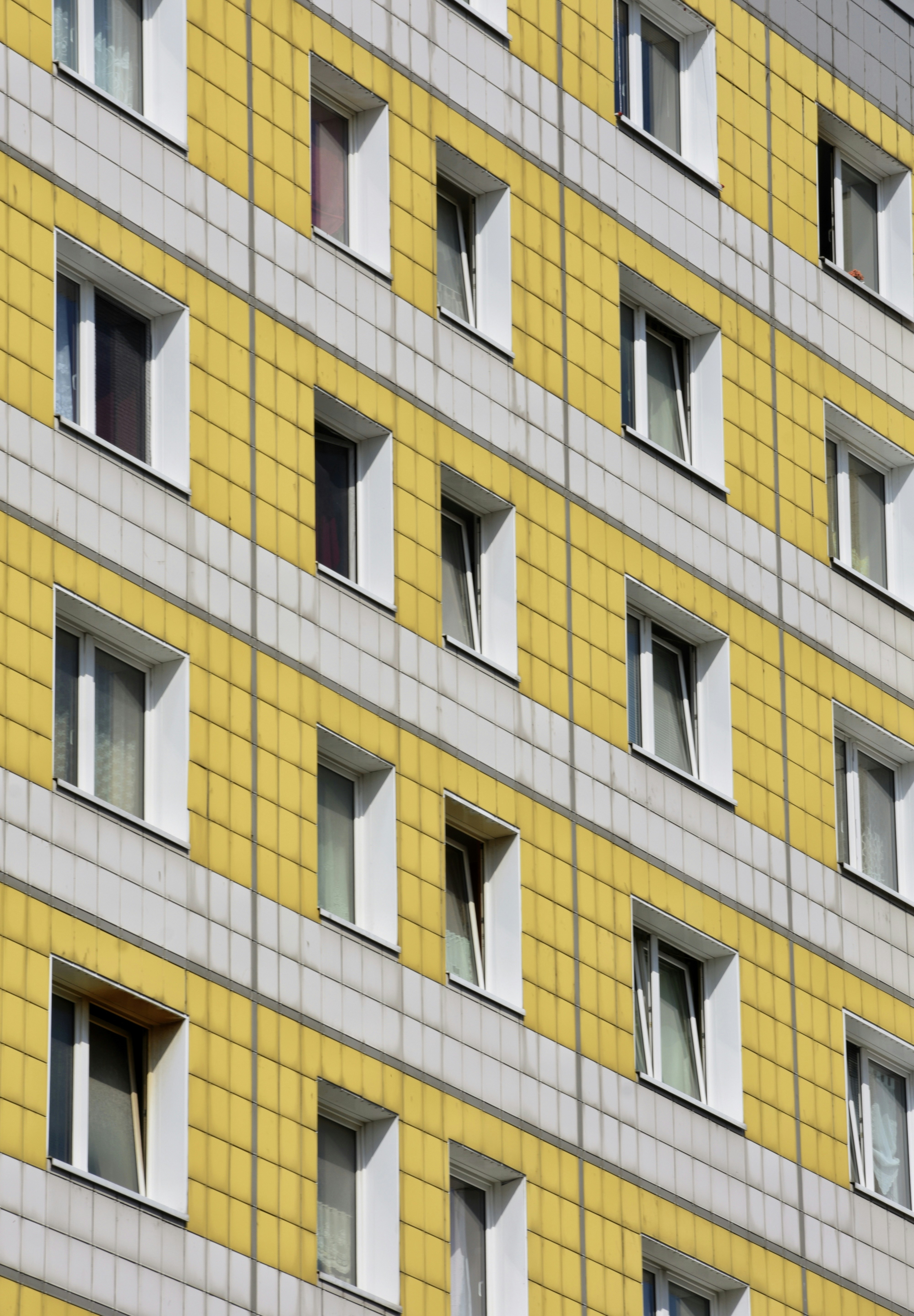 Un bâtiment jaune et gris avec de nombreuses fenêtres photo – Photo ...