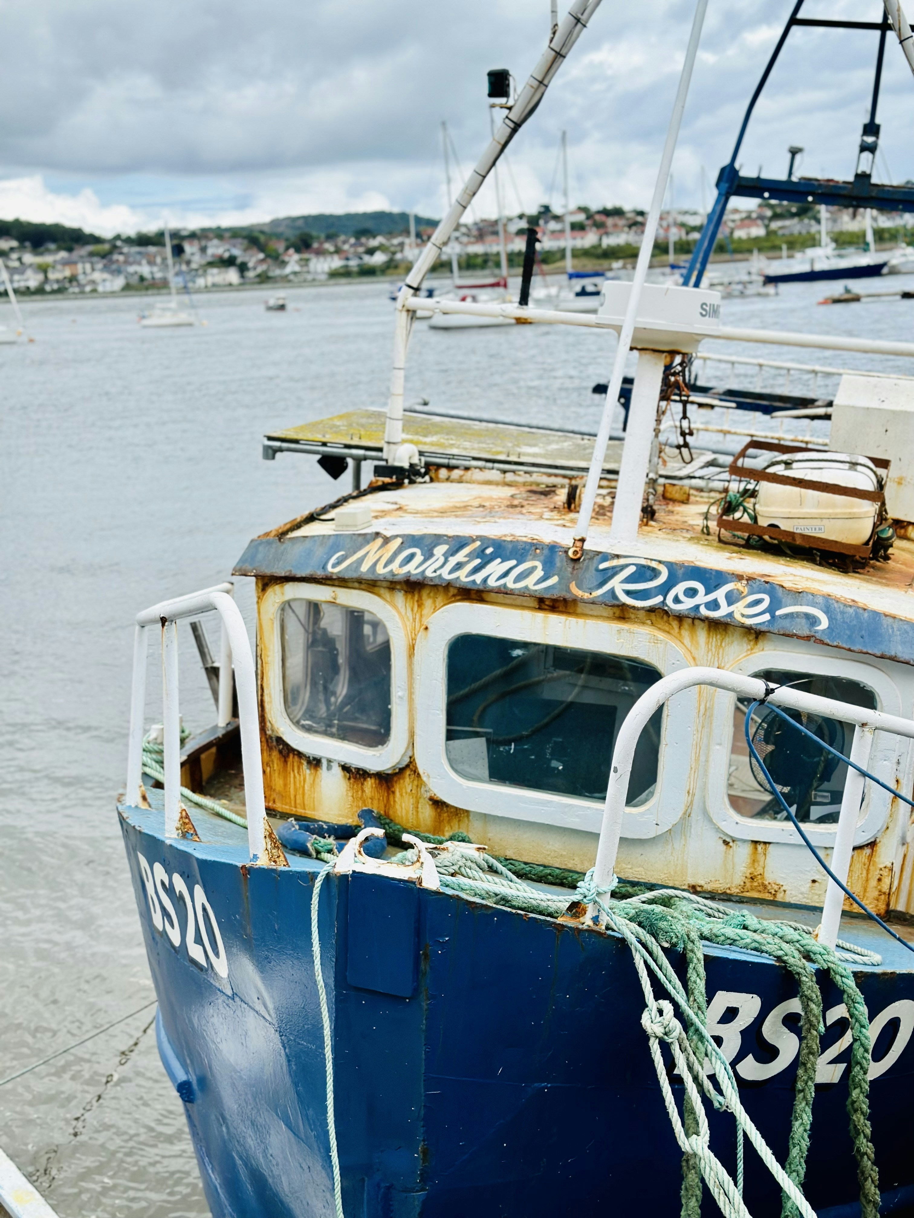 A rusted boat tied to a dock in the water photo – Free Sailboat Image ...