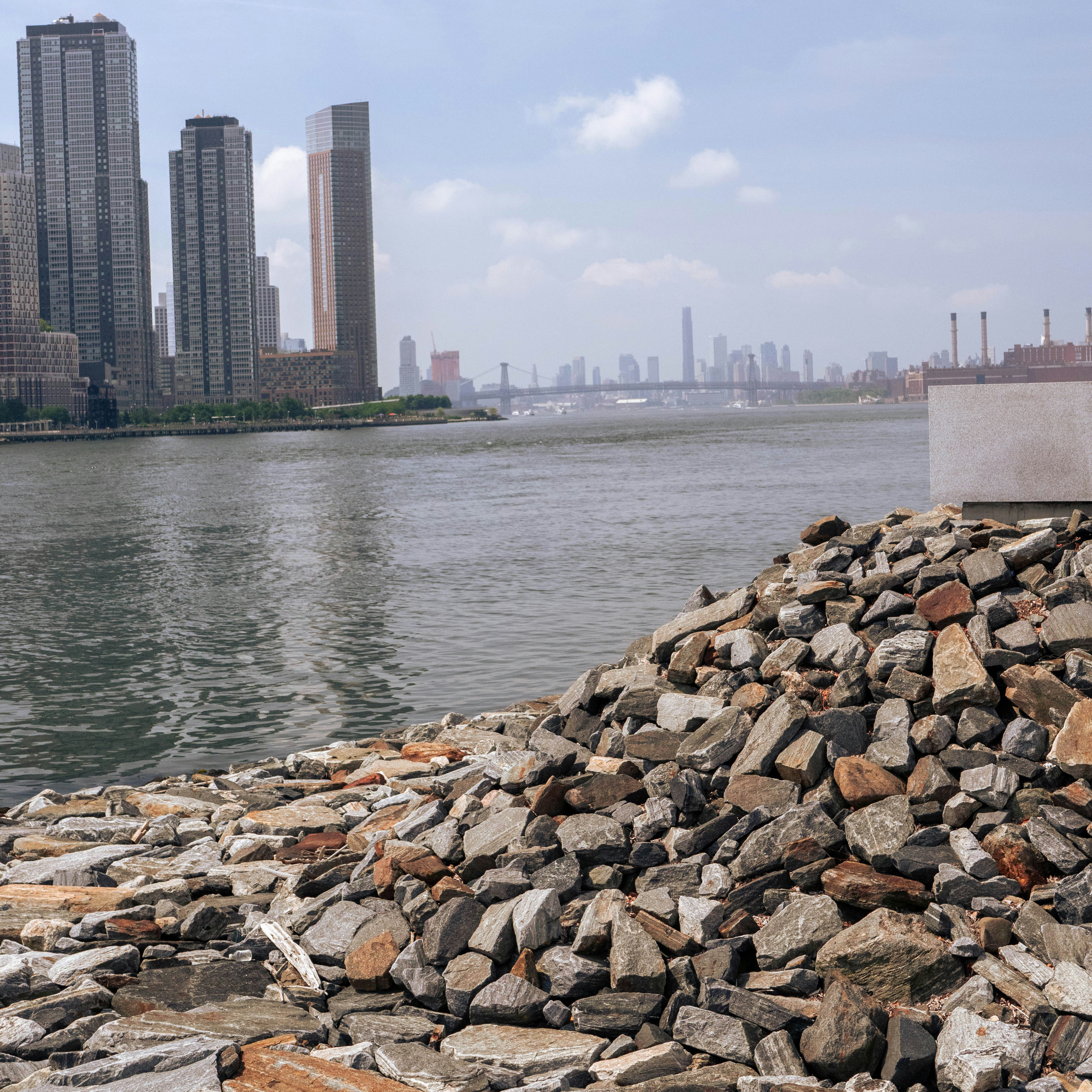Stone Breakwater Framing a Quiet Riverfront Skyline