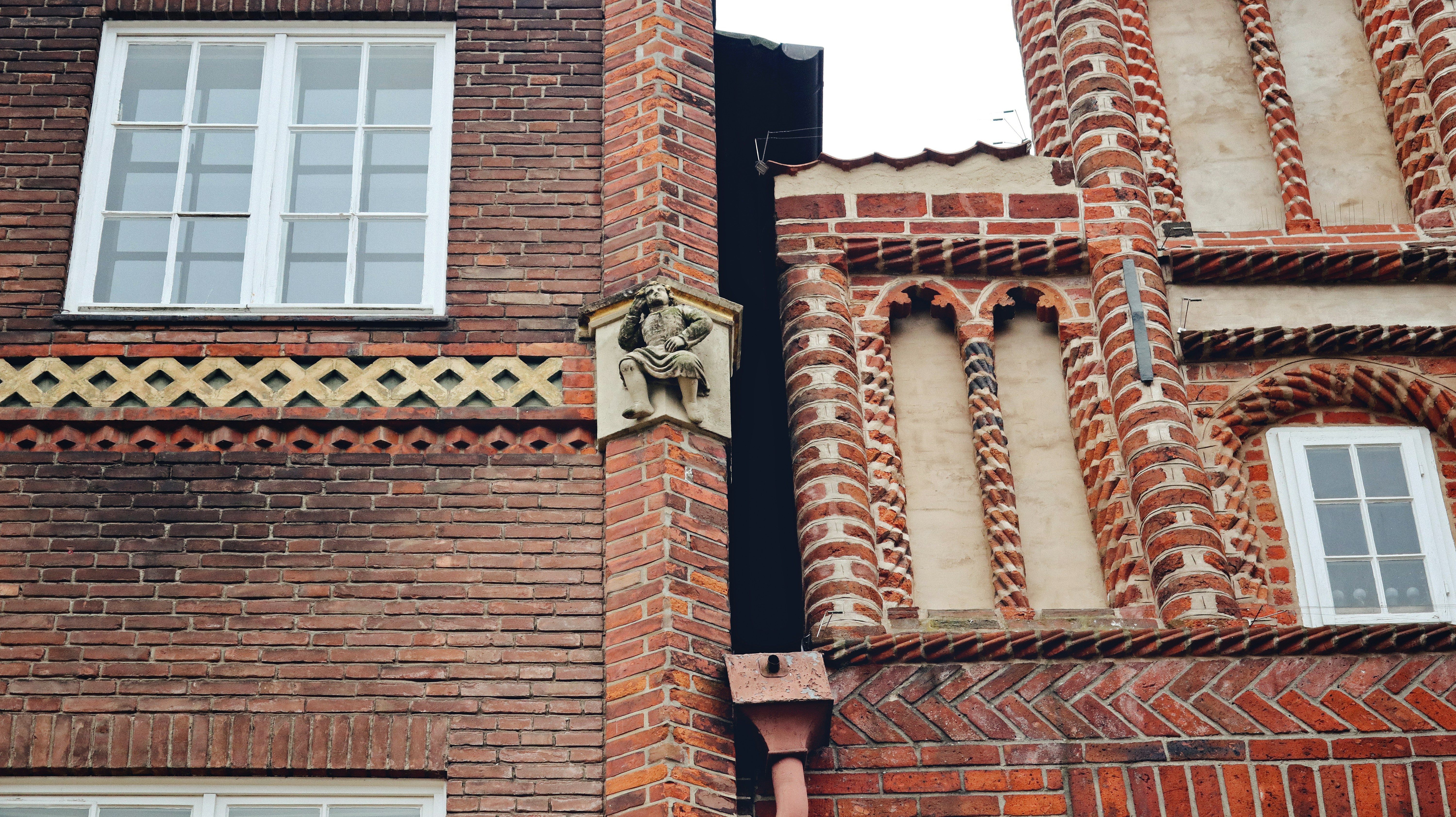Stone Bust Between Brickwork: A Quiet Portrait of a Historic Facade