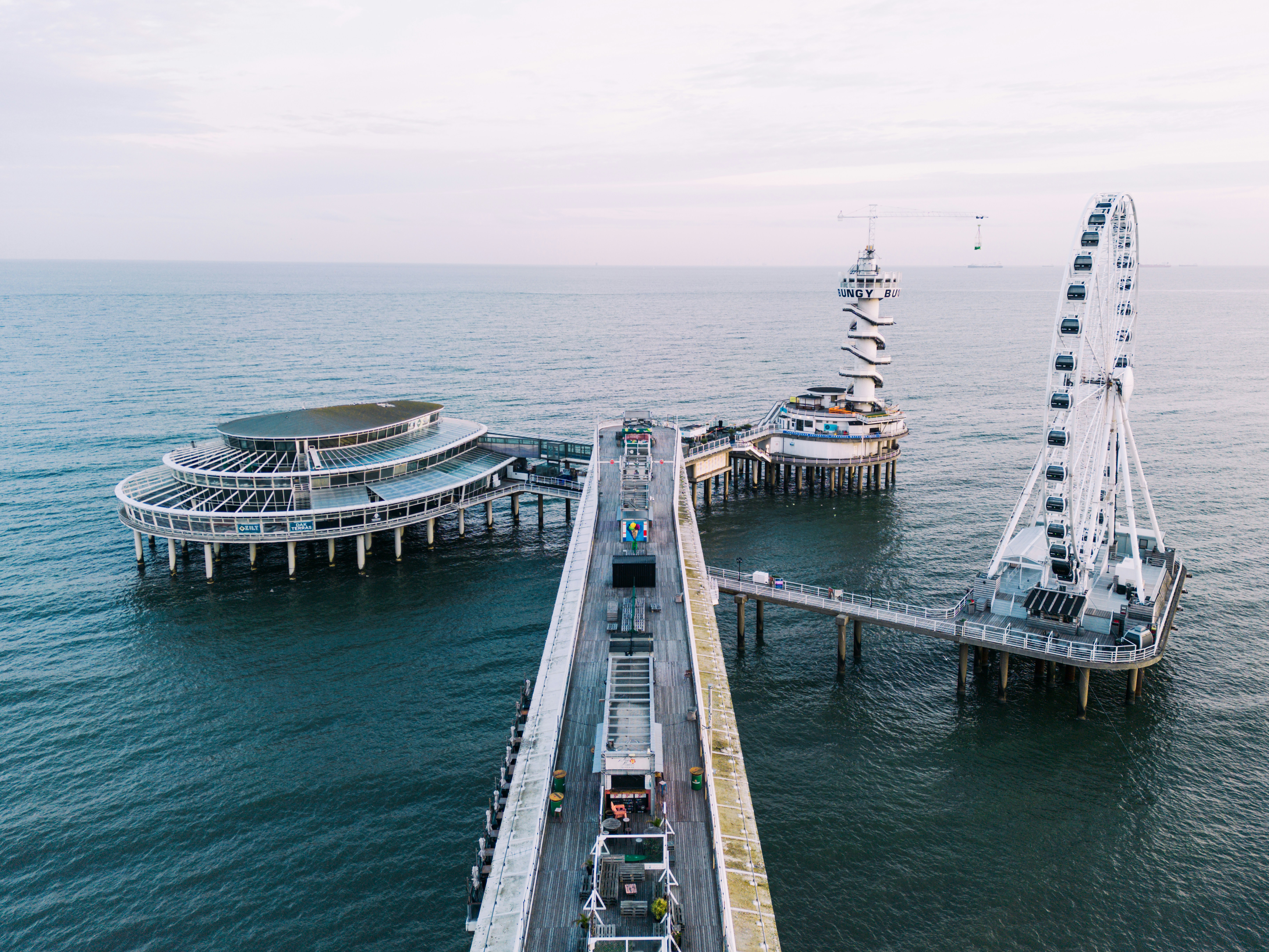 Una noria sentada en la parte superior de un muelle junto al océano ...