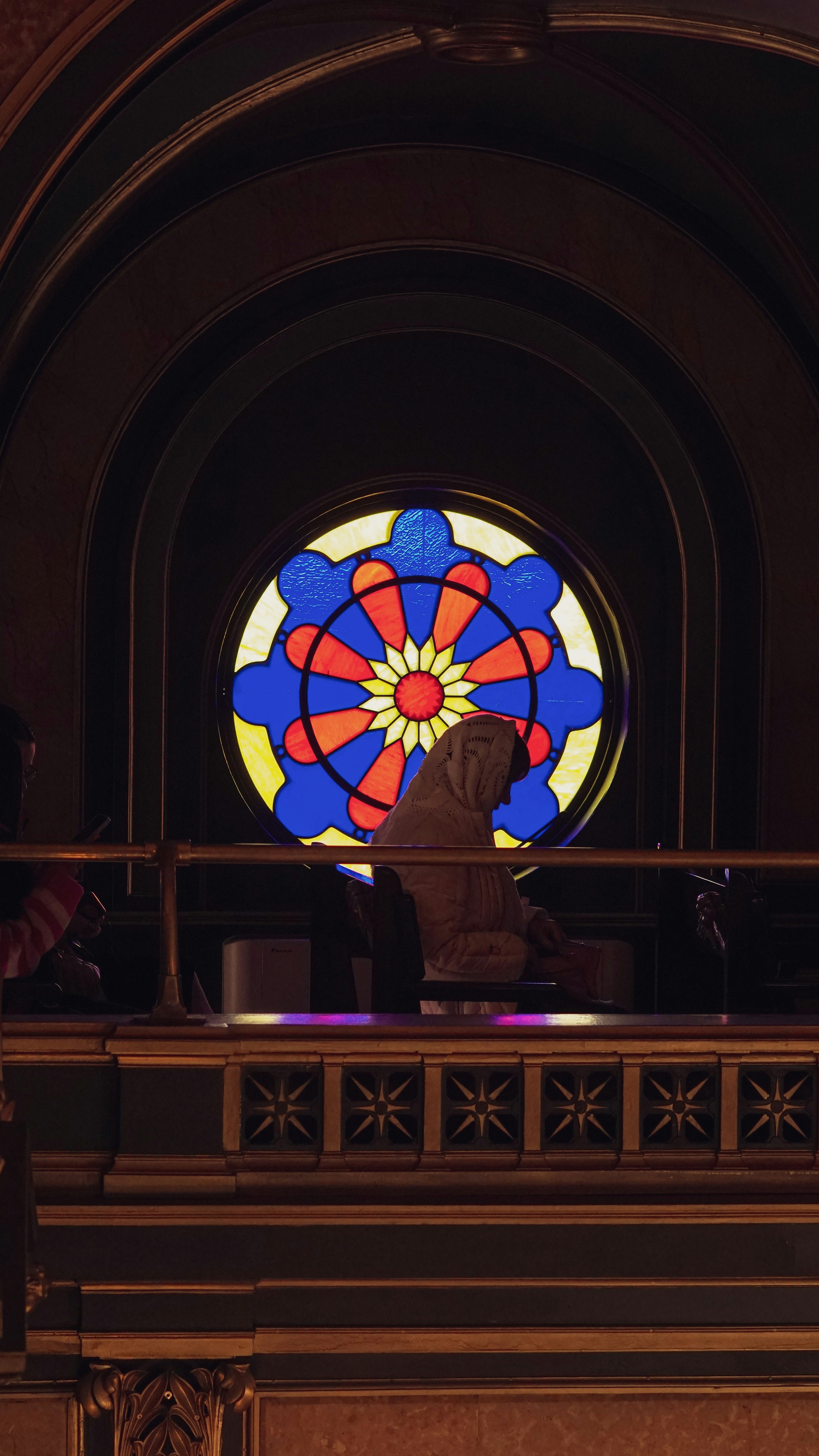 Circle of Light Framed by a Silent Figure in a Dim Nave
