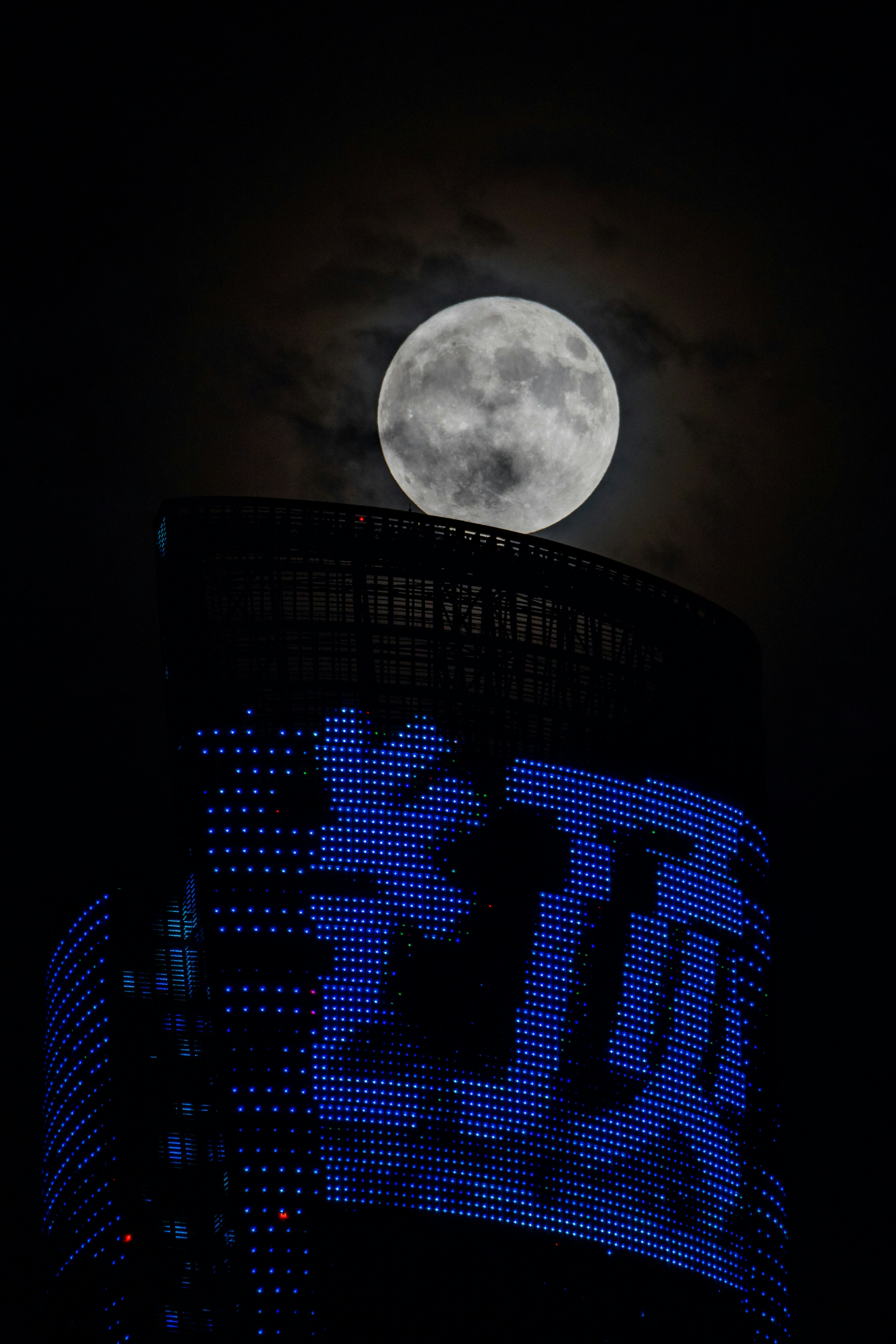 Moonrise Behind a Neon Cylinder: Blue Lightscape in Night City