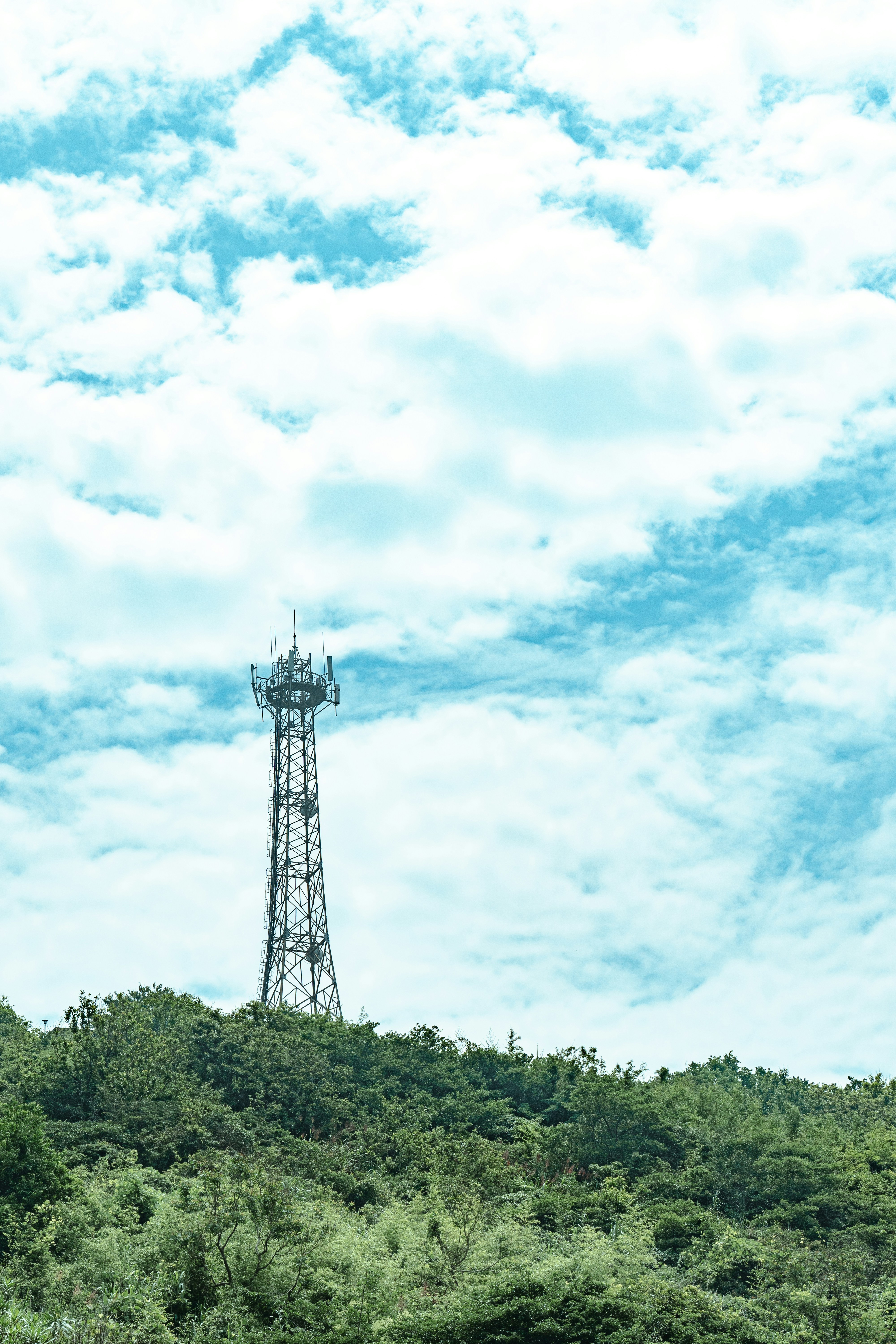 Telecom Peak: Tower Rising Above Green Hills Under a Bright Sky