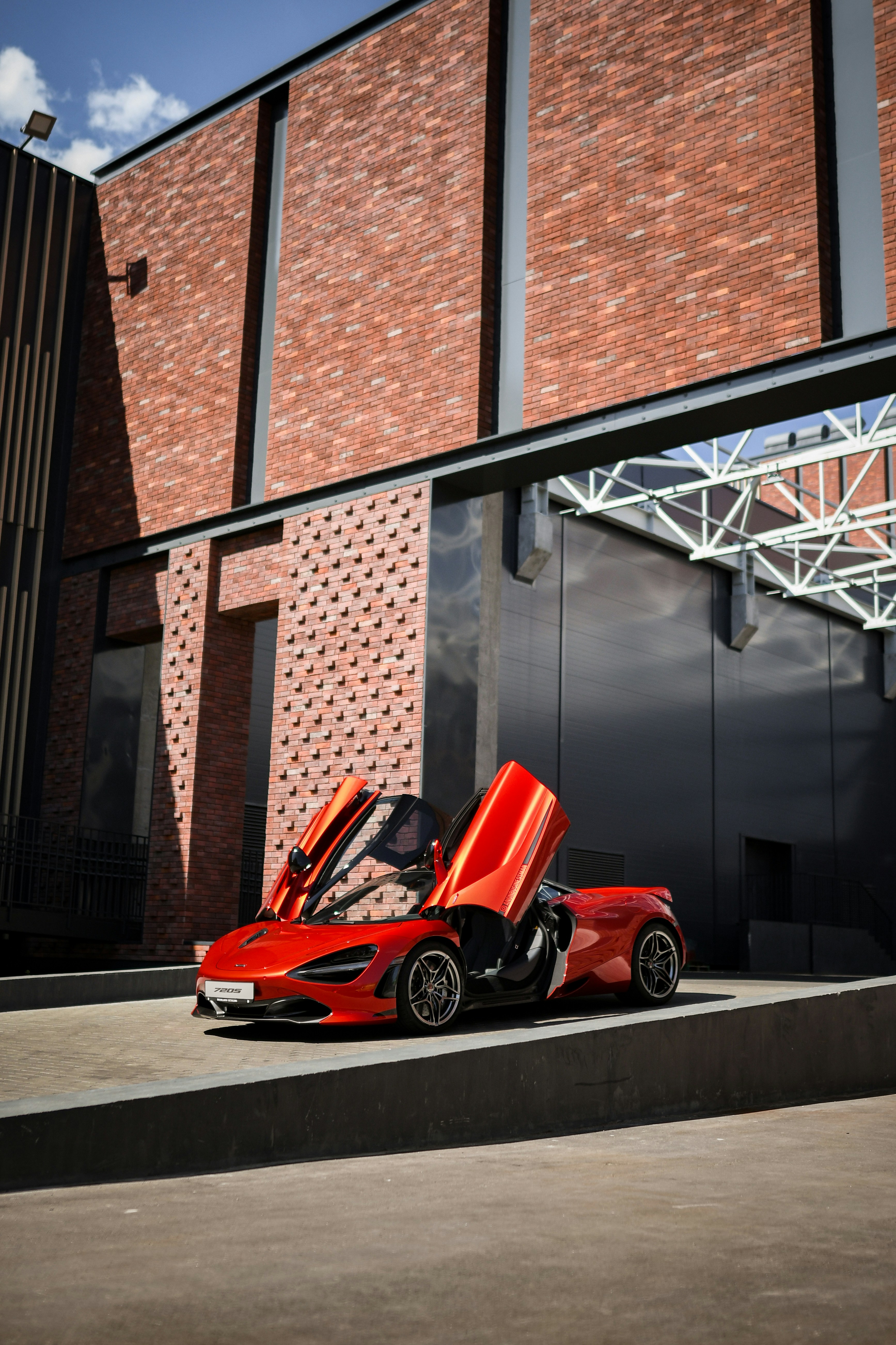 A red sports car parked in front of a brick building photo – Free Saint ...