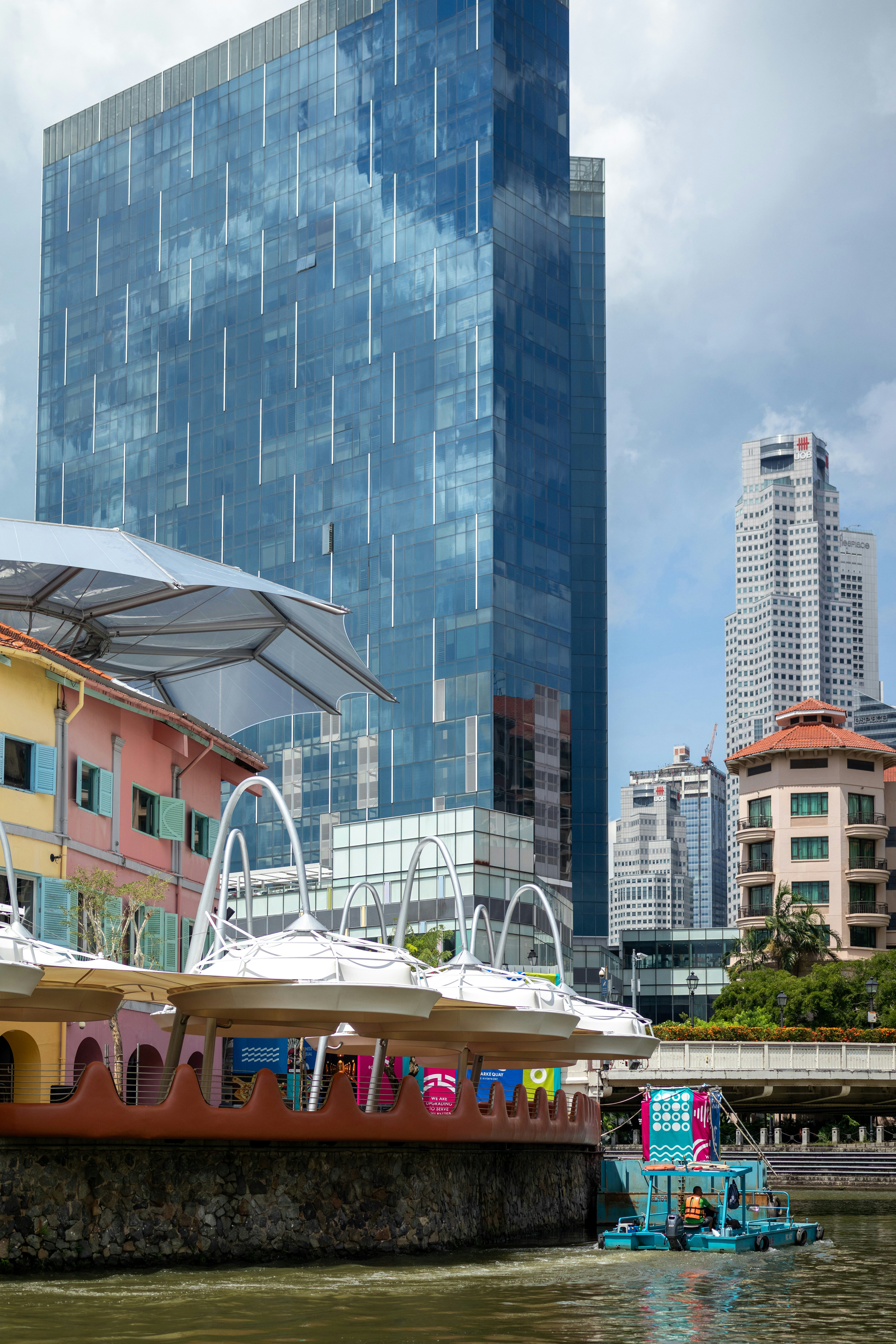 Glass Cloak Over Cityline: A Riverside Array of Color and Curves