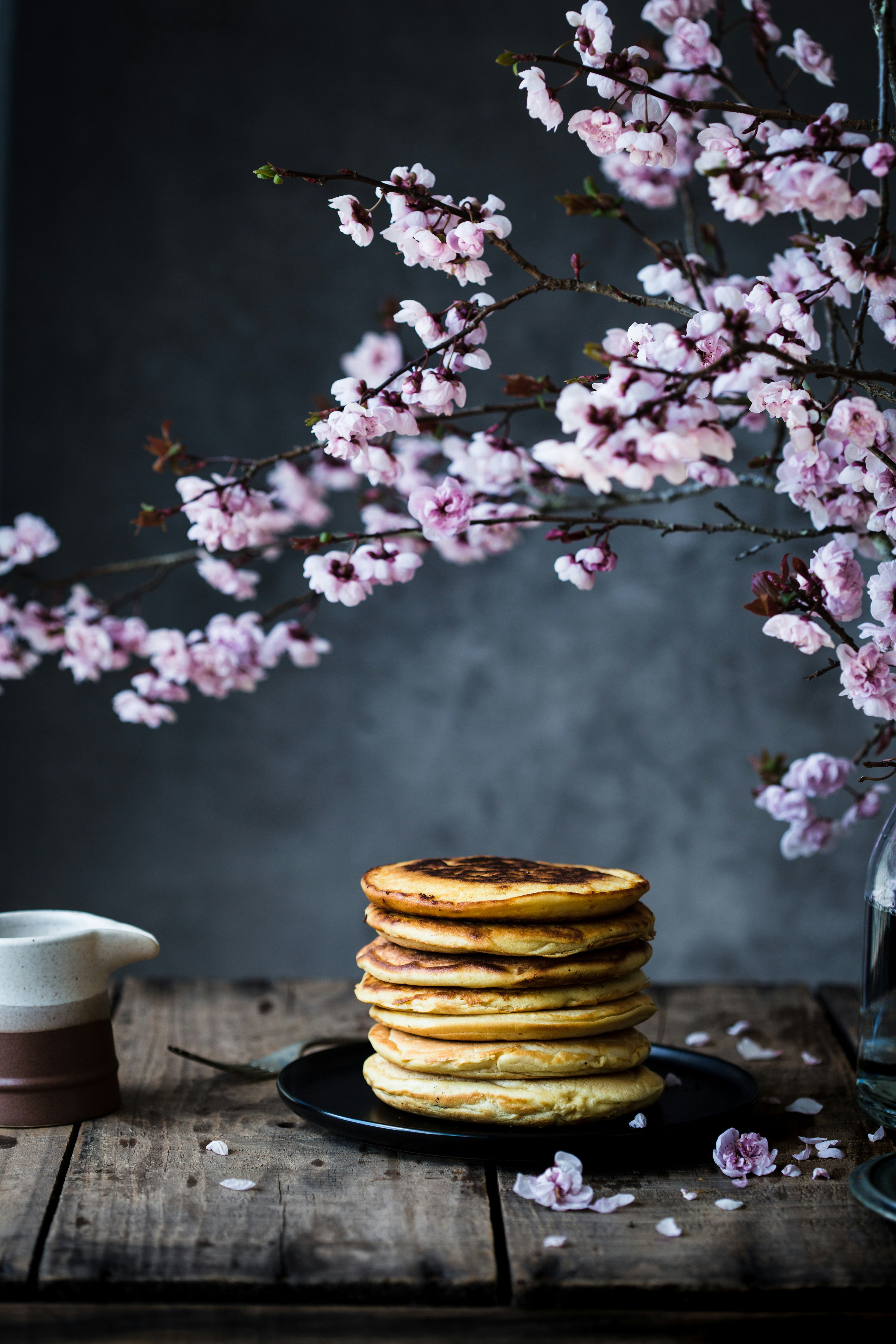 Cherry Blossom Drapes Over a Rustic Pancake Still-Life