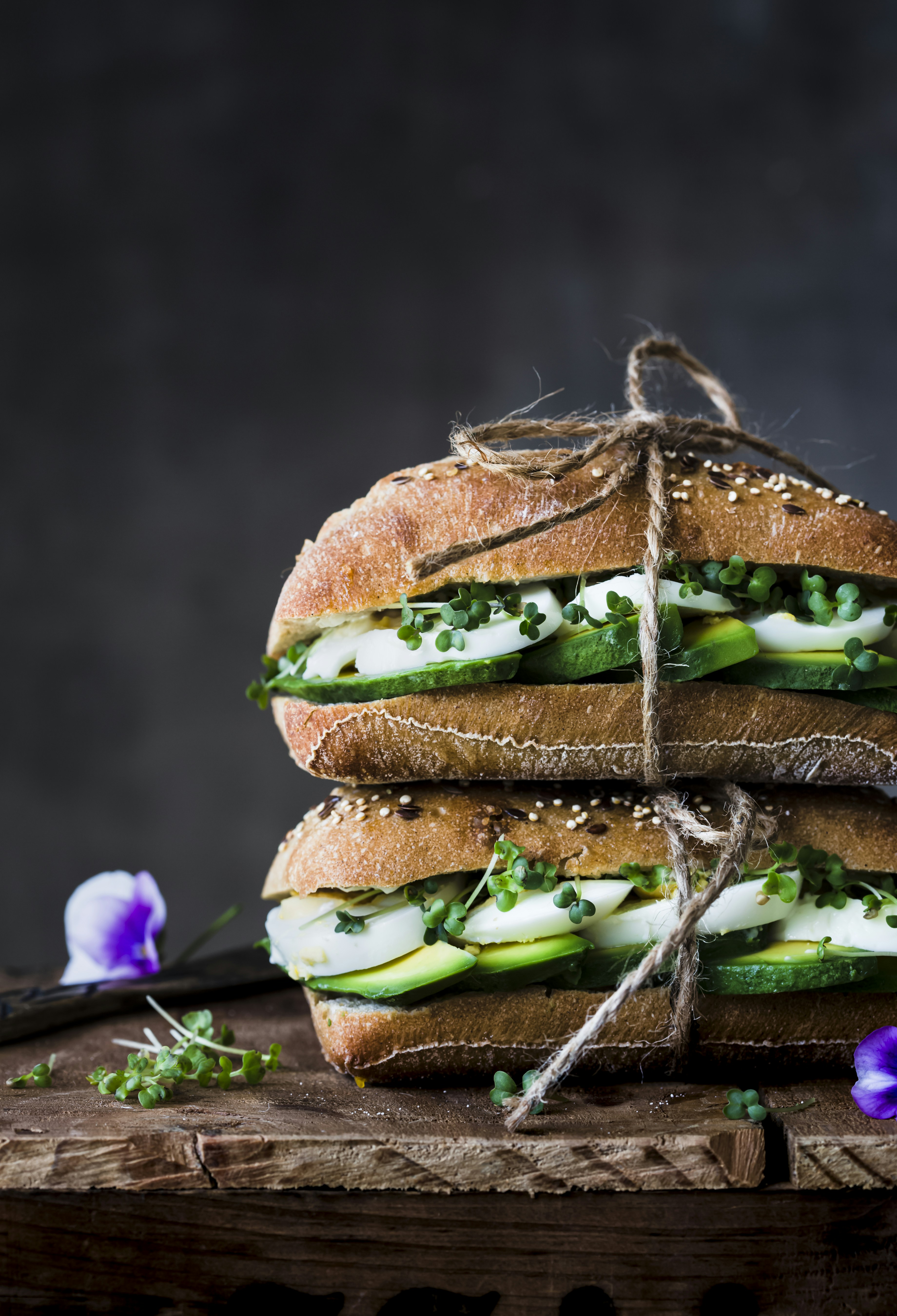 Twine-Tied Veggie Stack: Sesame Buns and Fresh Greens on a Weathered Board