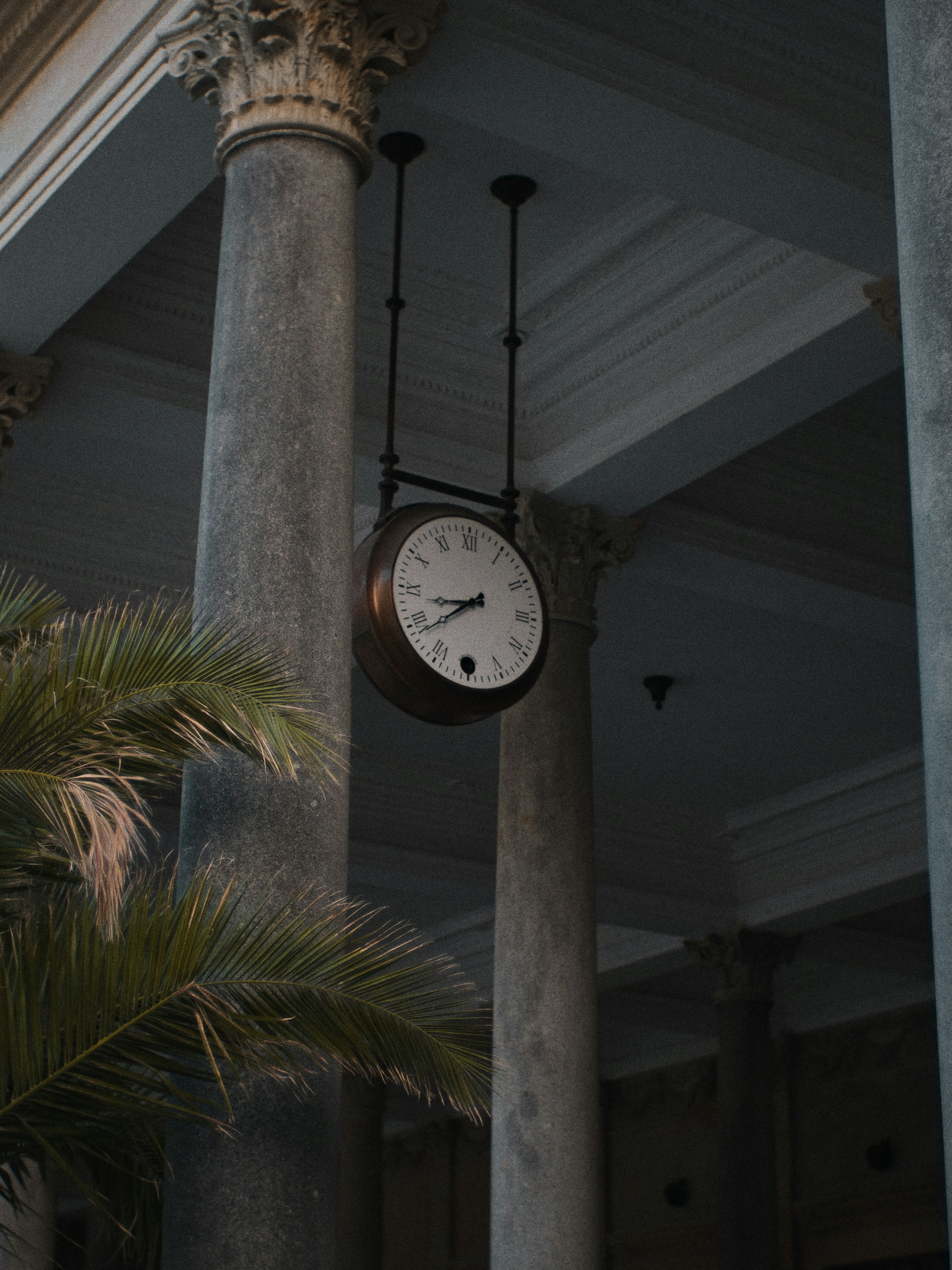 Timekeeper in the Portico: Clock Between Ancient Columns