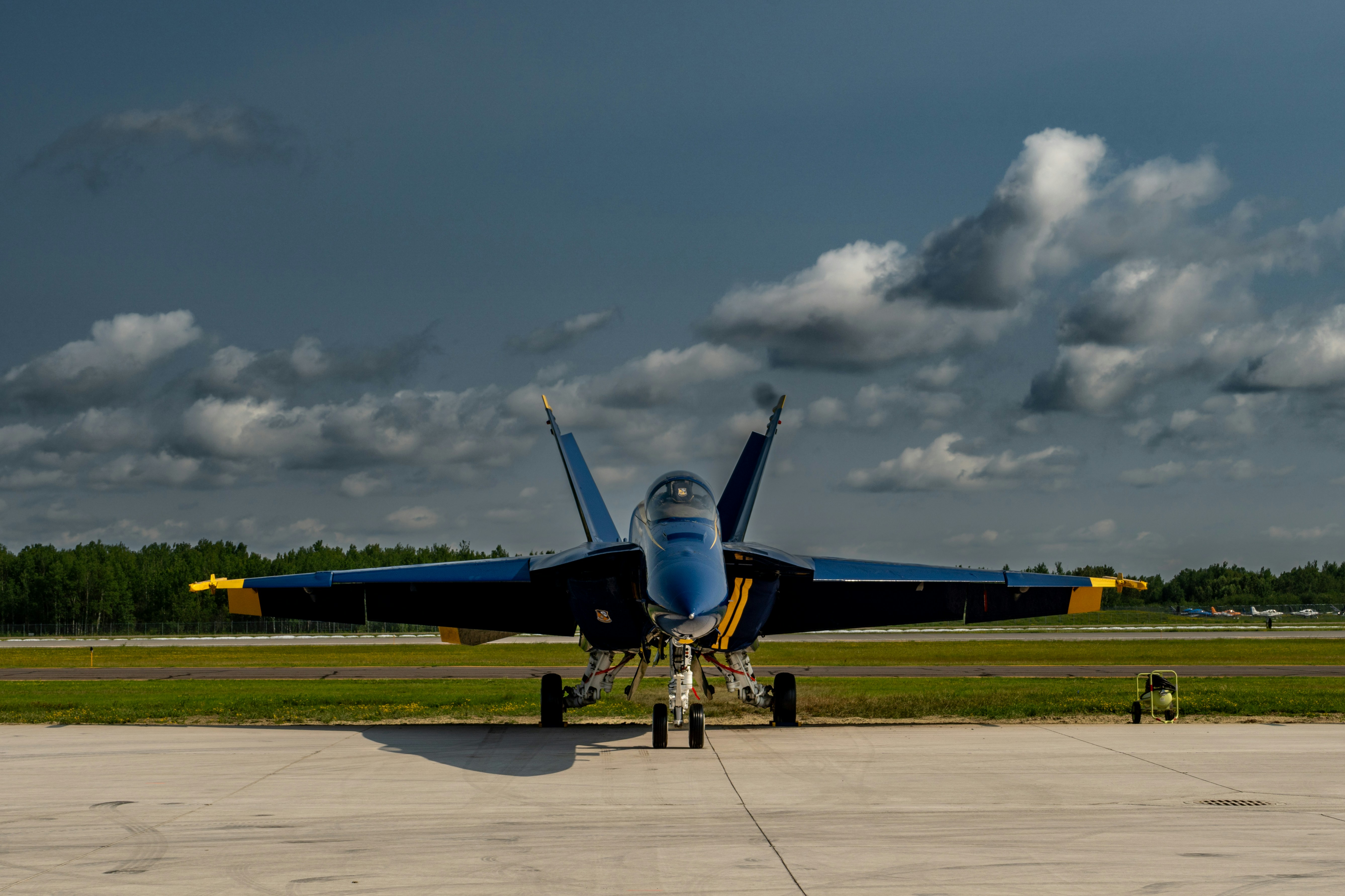 A blue and yellow jet sitting on top of an airport tarmac photo – Free ...