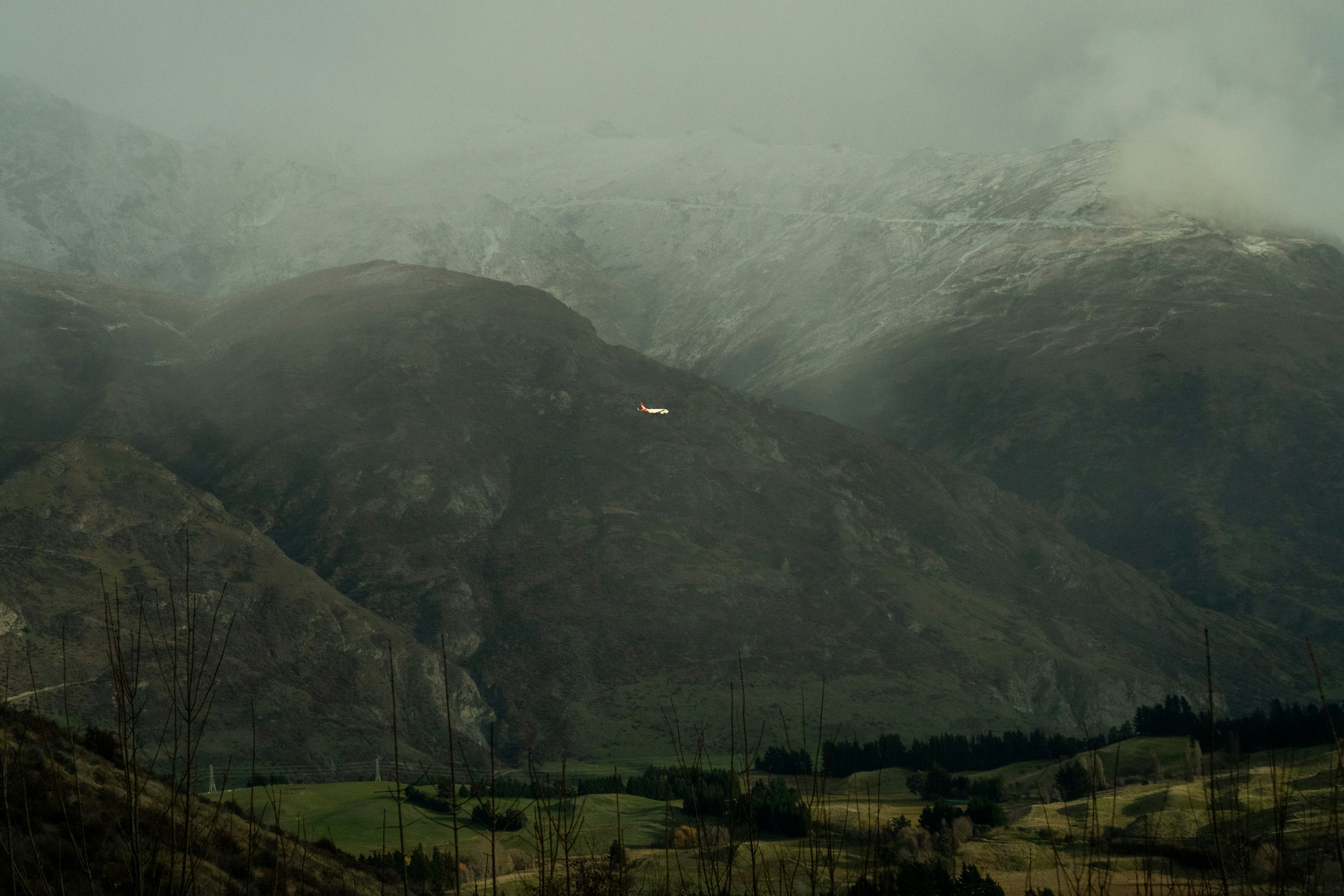Lone Glint over the Valley: A Hilltop Light in Mist