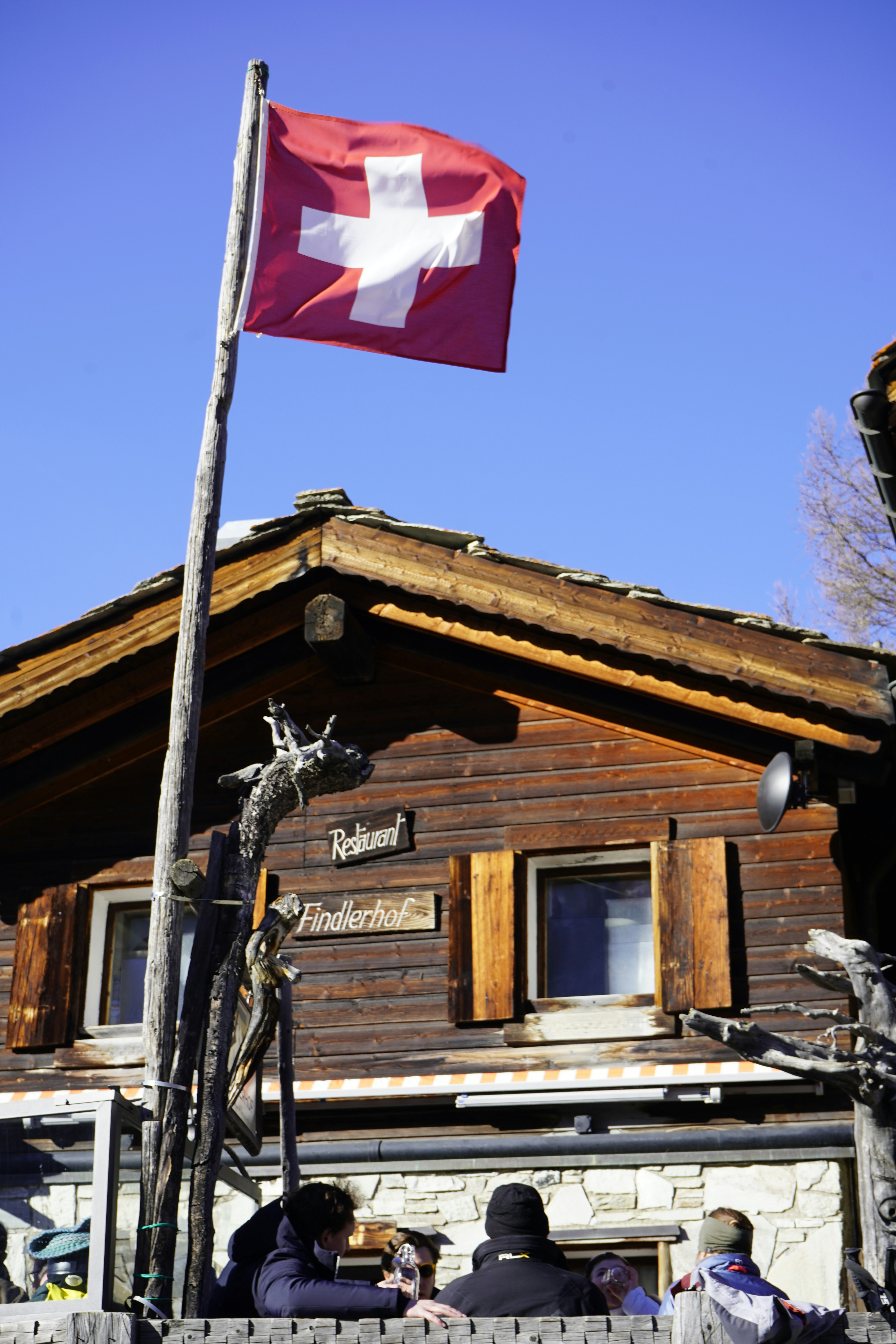 Swiss Cross Above the Alpine Lodge: Findlerhof in a Clear Day