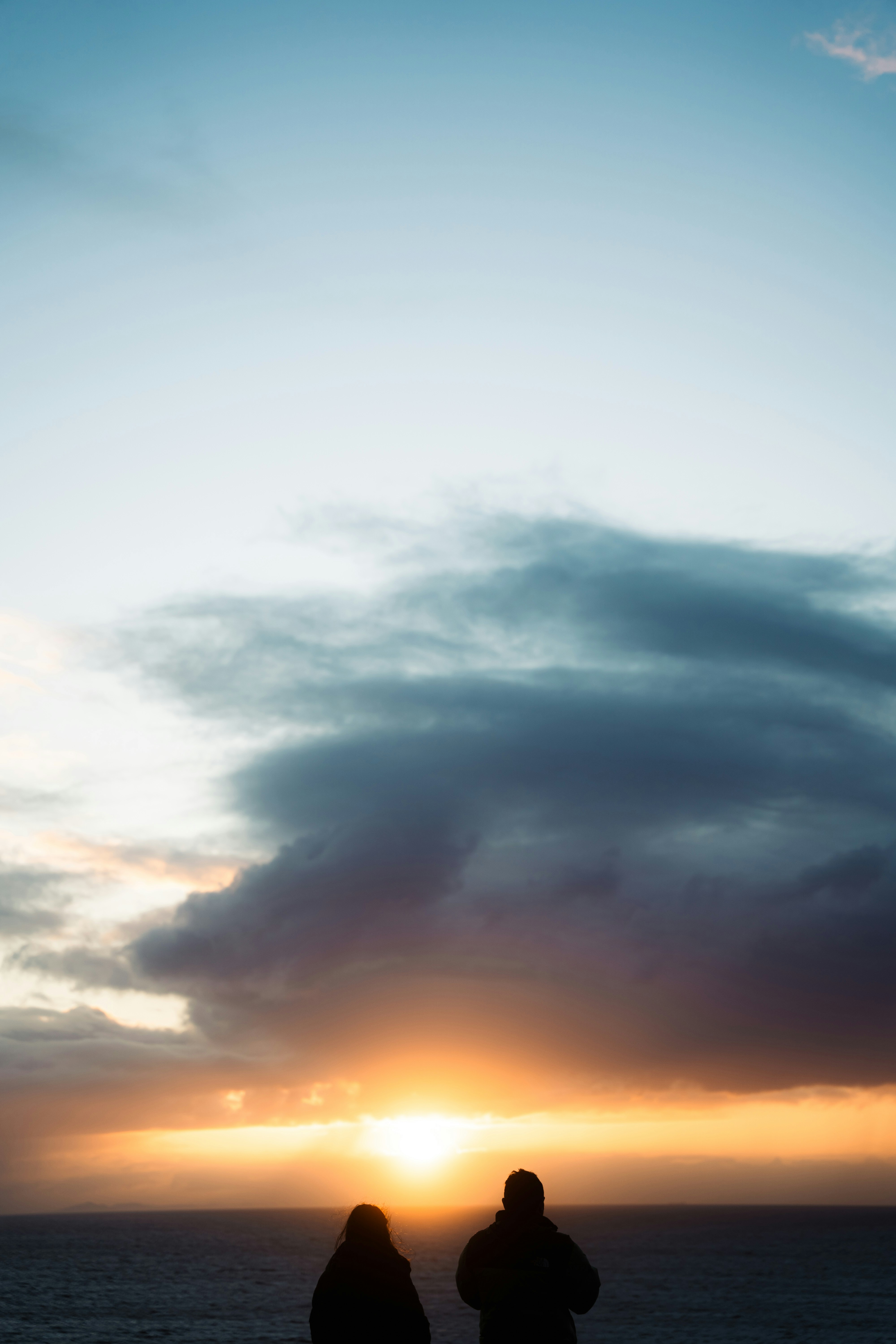 A couple of people standing on top of a beach photo – Free Nature Image ...